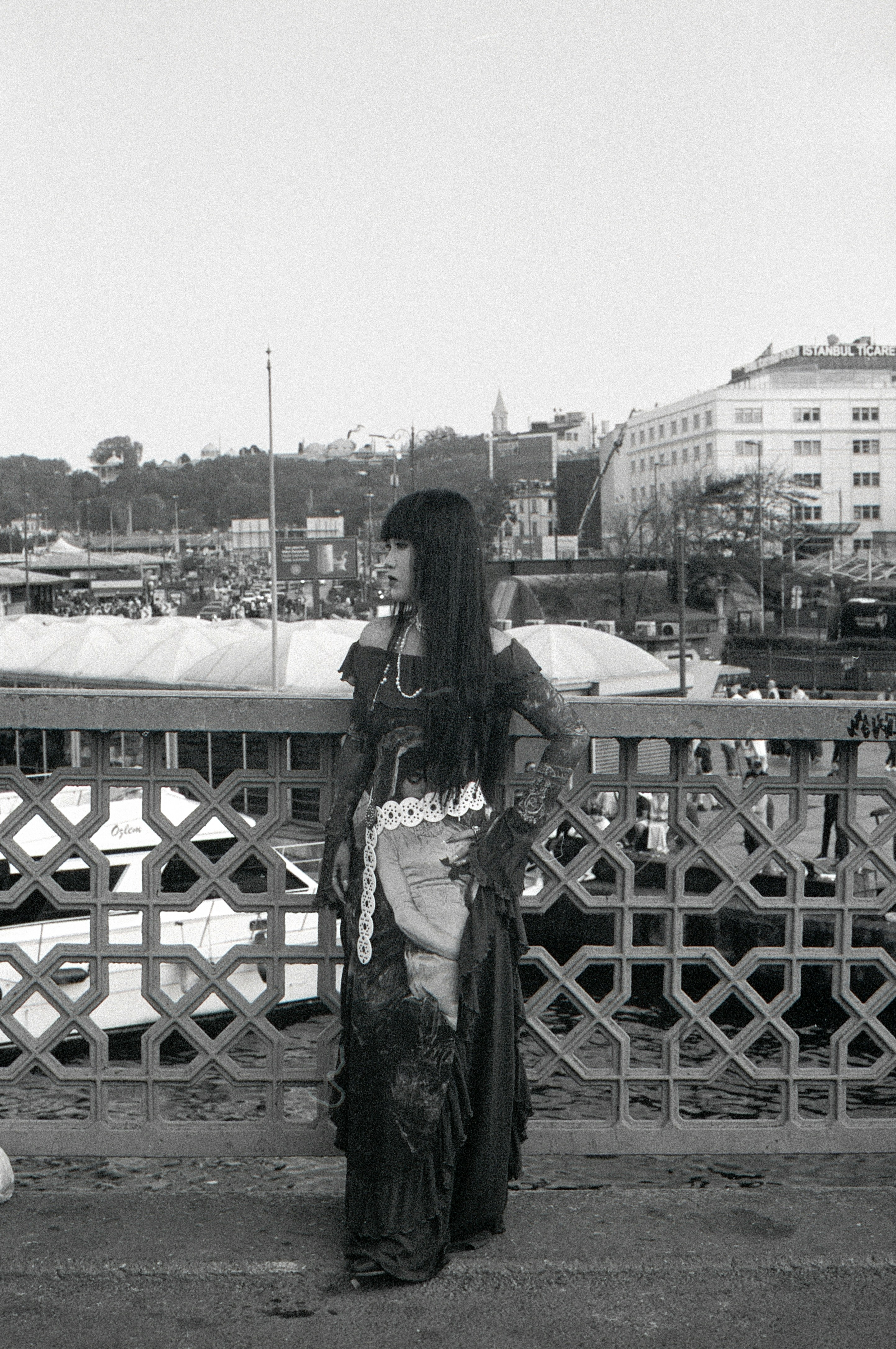 A woman in a costume stands on a bridge.