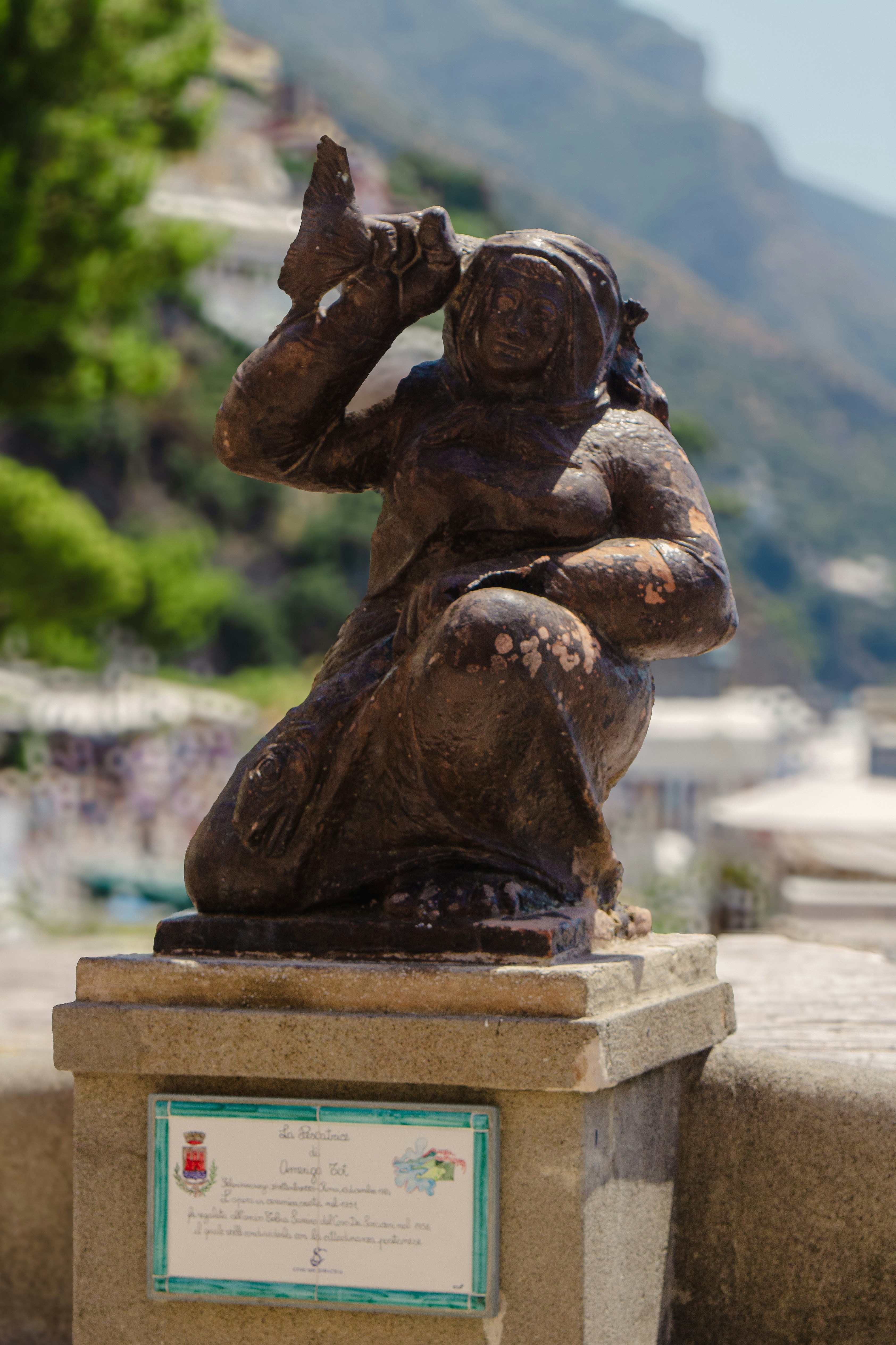 Harbor Sentinel: Weathered Bronze Statue by the Seaside Rail