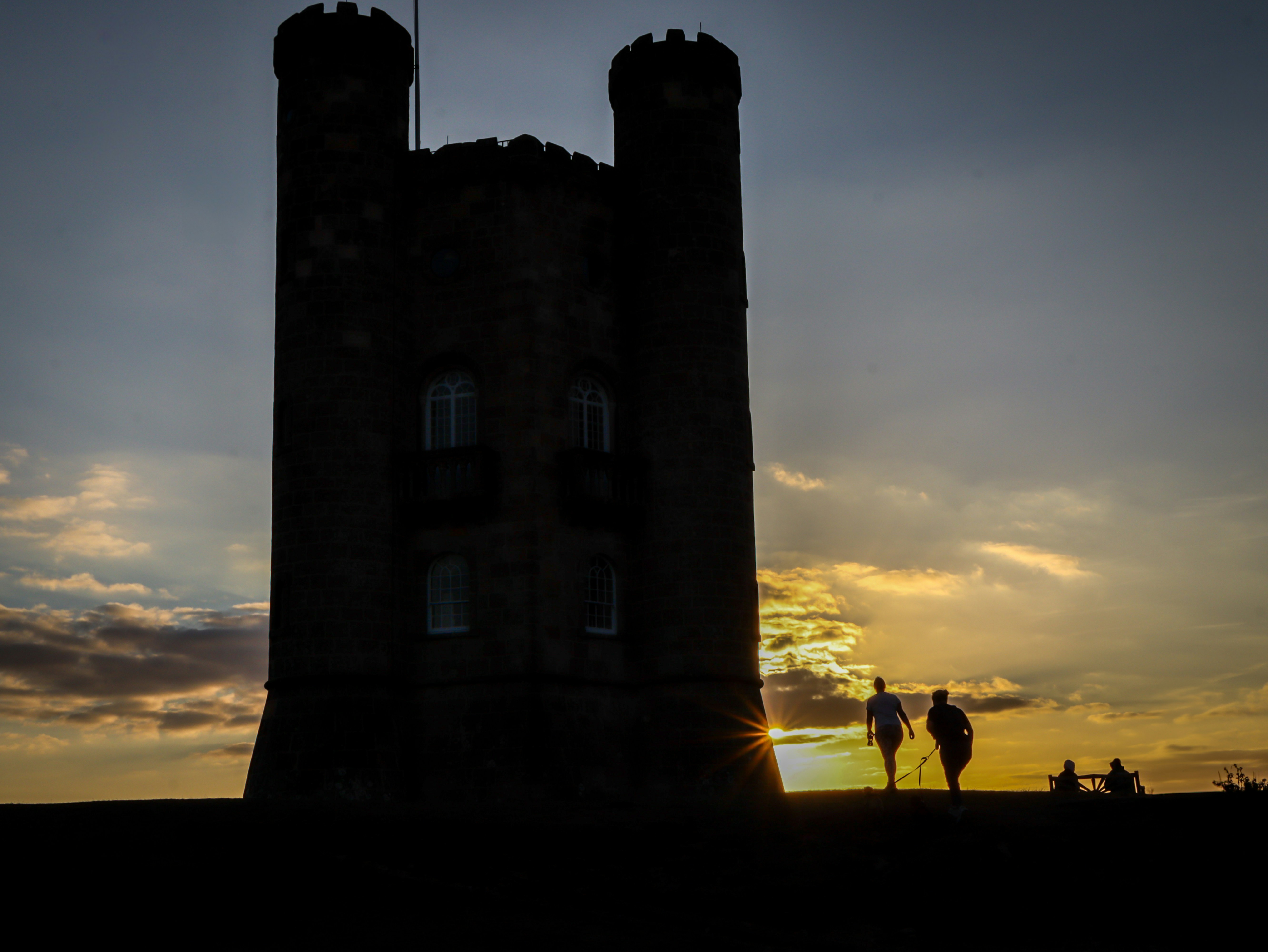 Dusk at the Gatehouse: Silhouettes Along a Golden Horizon