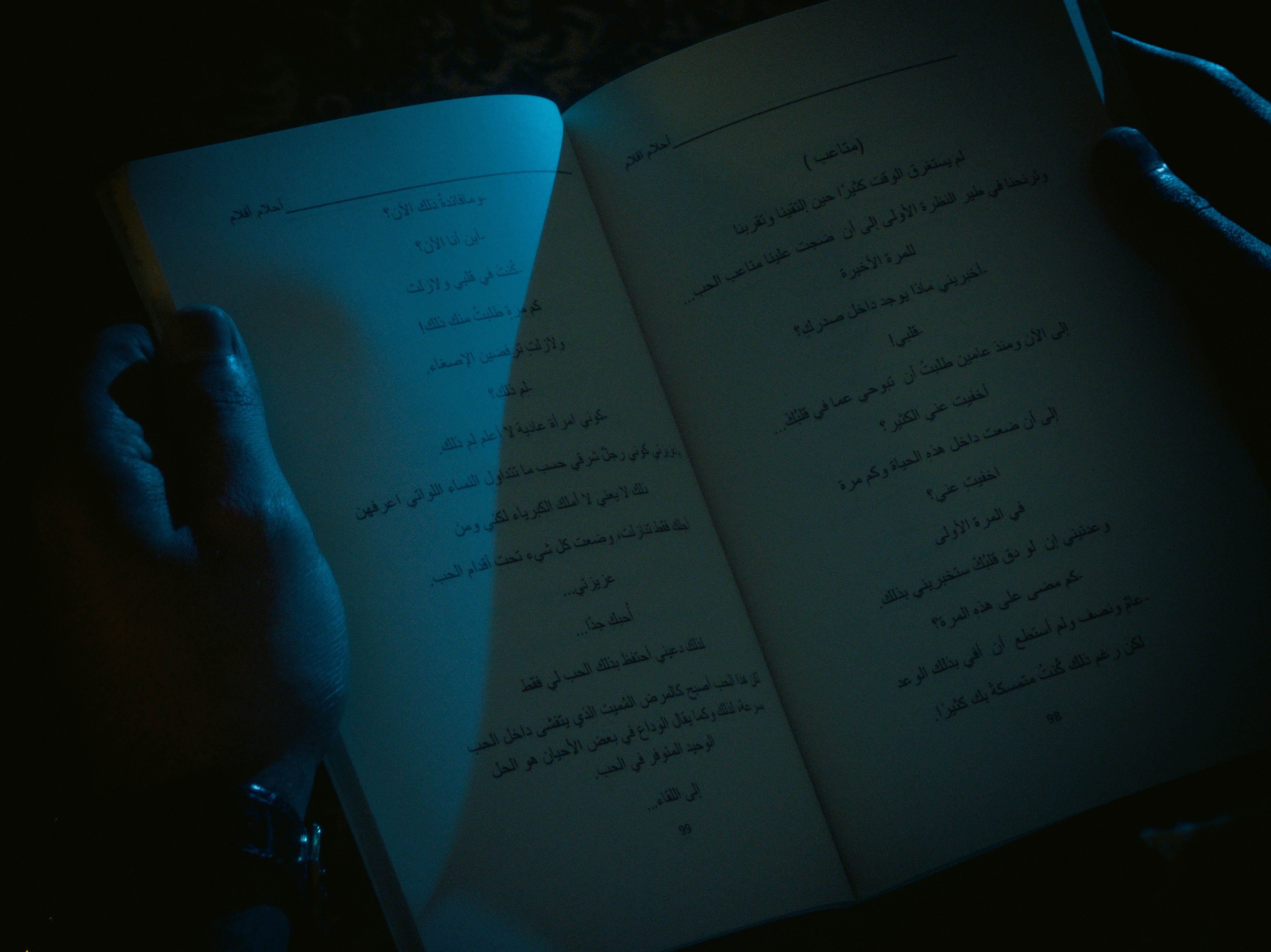 A person's hands turning pages of an open book.