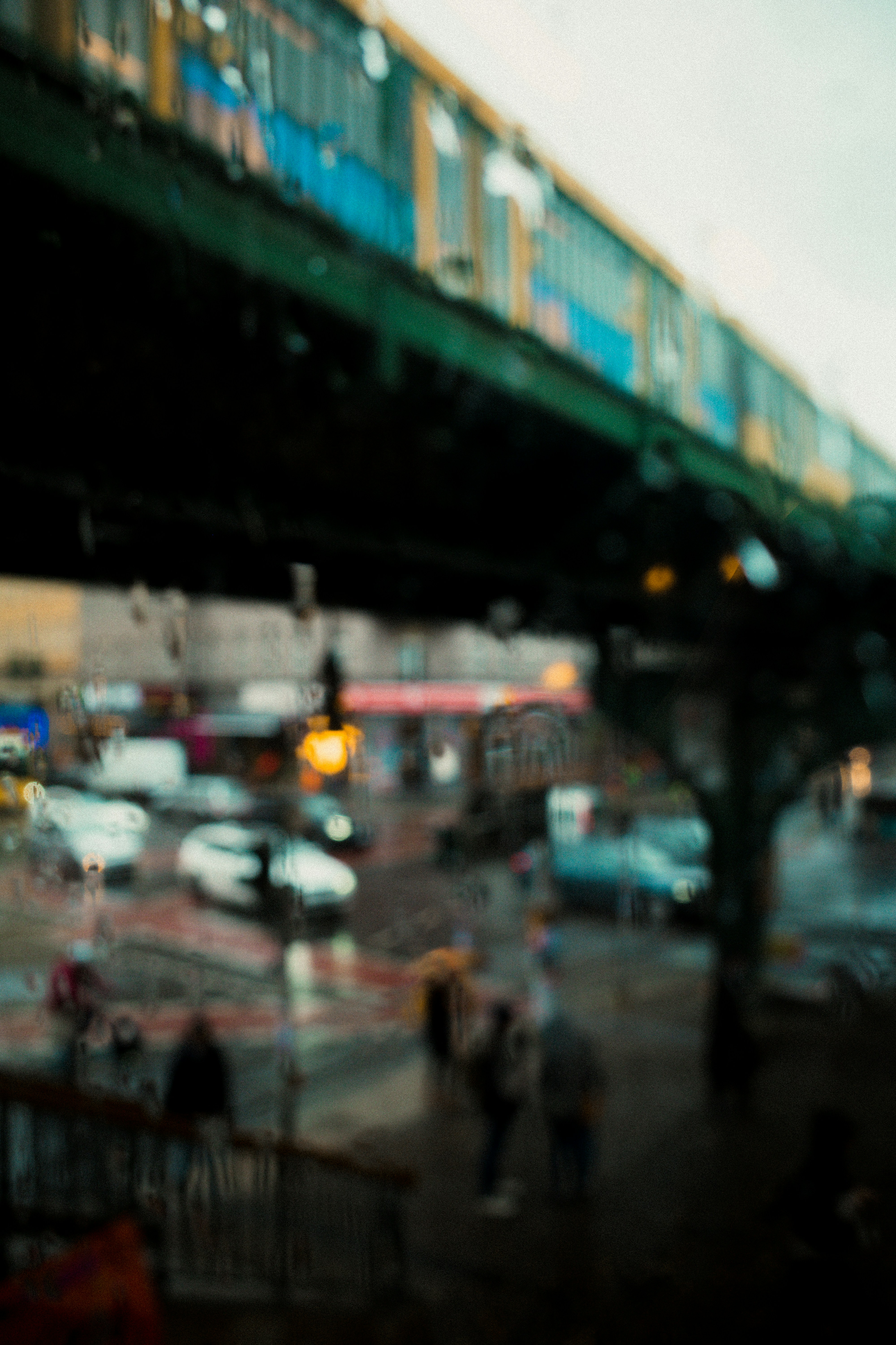Under the Elevated Veil: Neon Blur Across a Rainy City Crossing