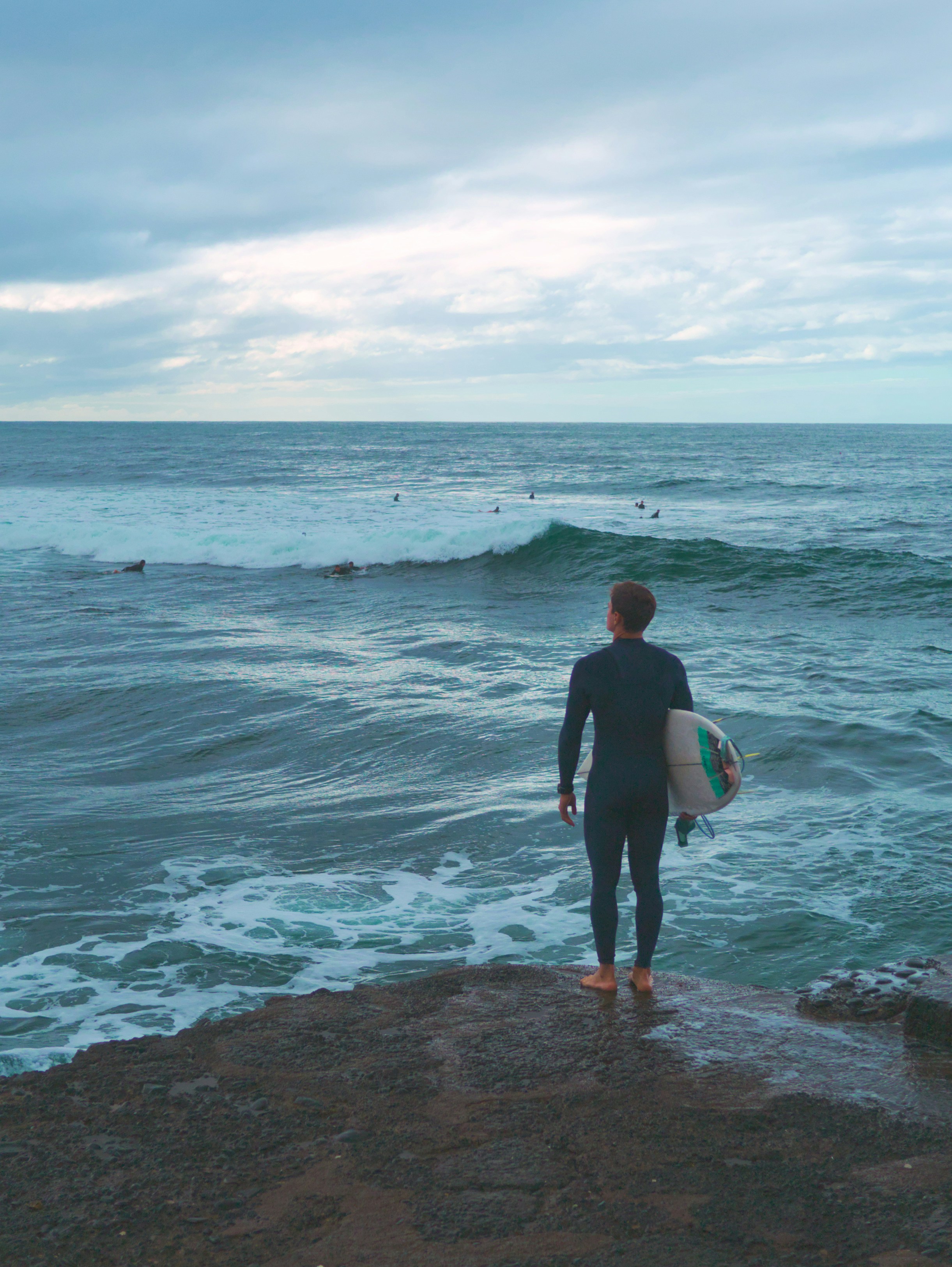 Edge of the Break: A lone surfer surveys the Atlantic from the rocky shoreline