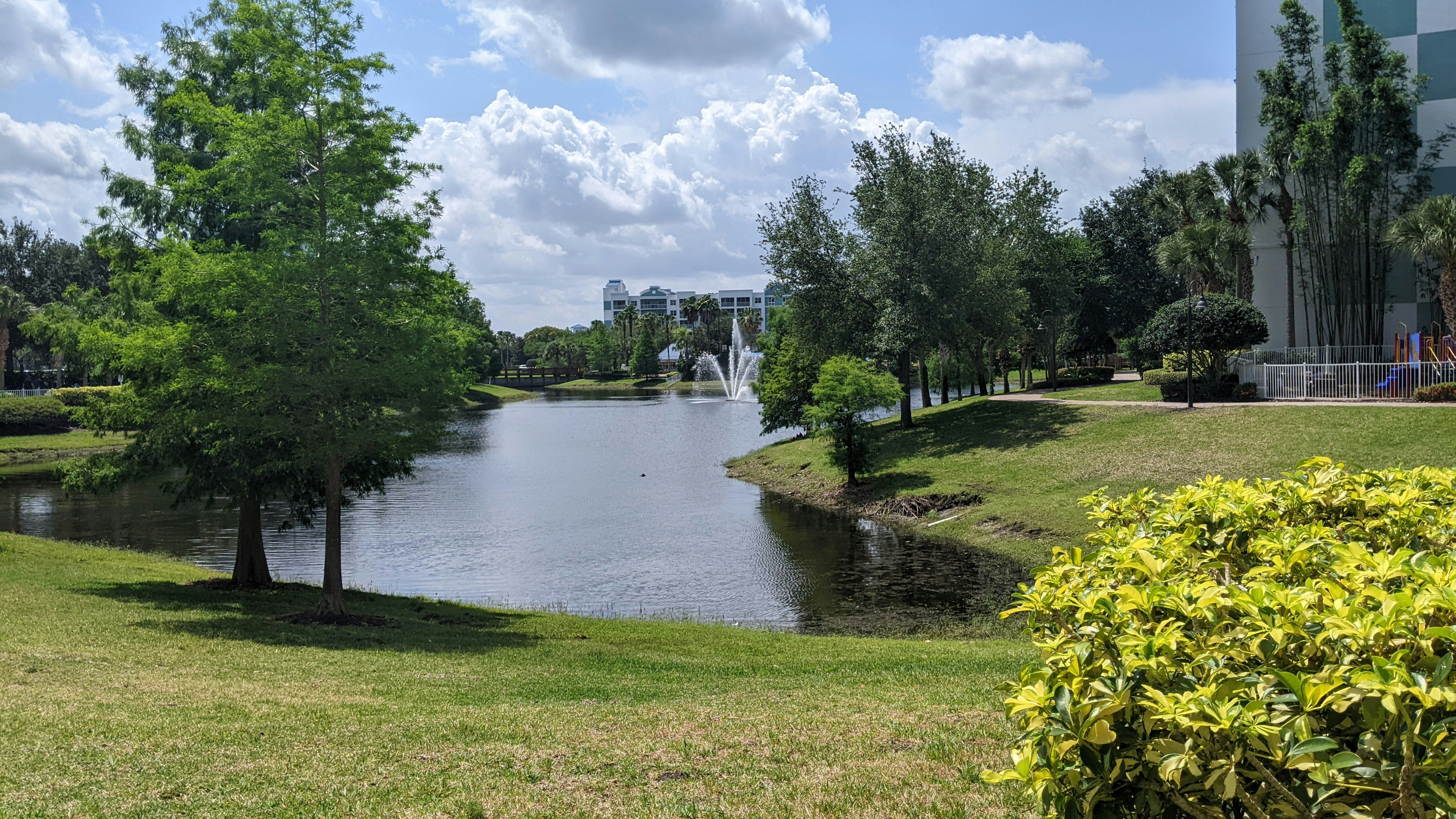 Central Fountain Over a Calm City Park Pond