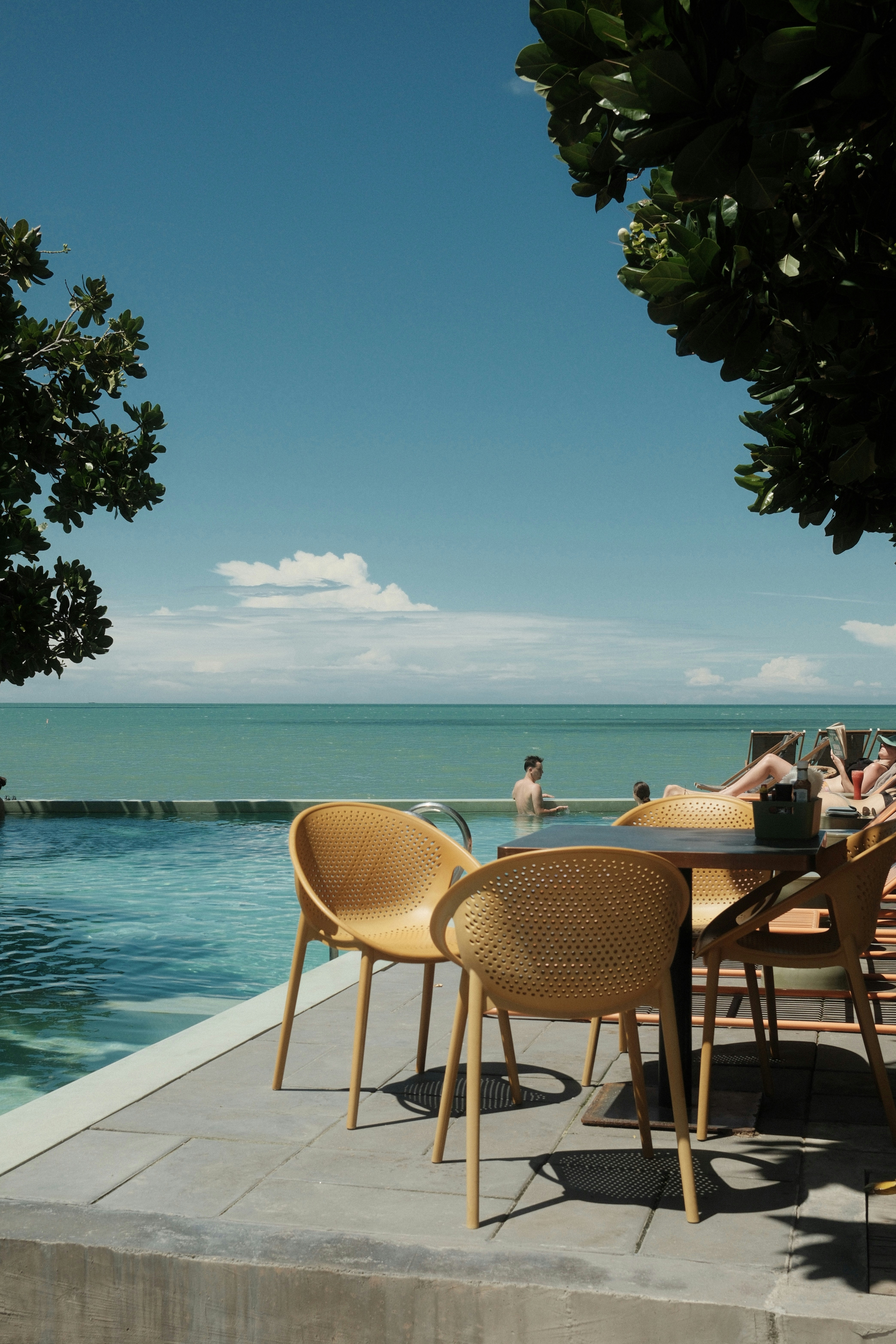 Poolside Amber Chairs Framing a Turquoise Sea