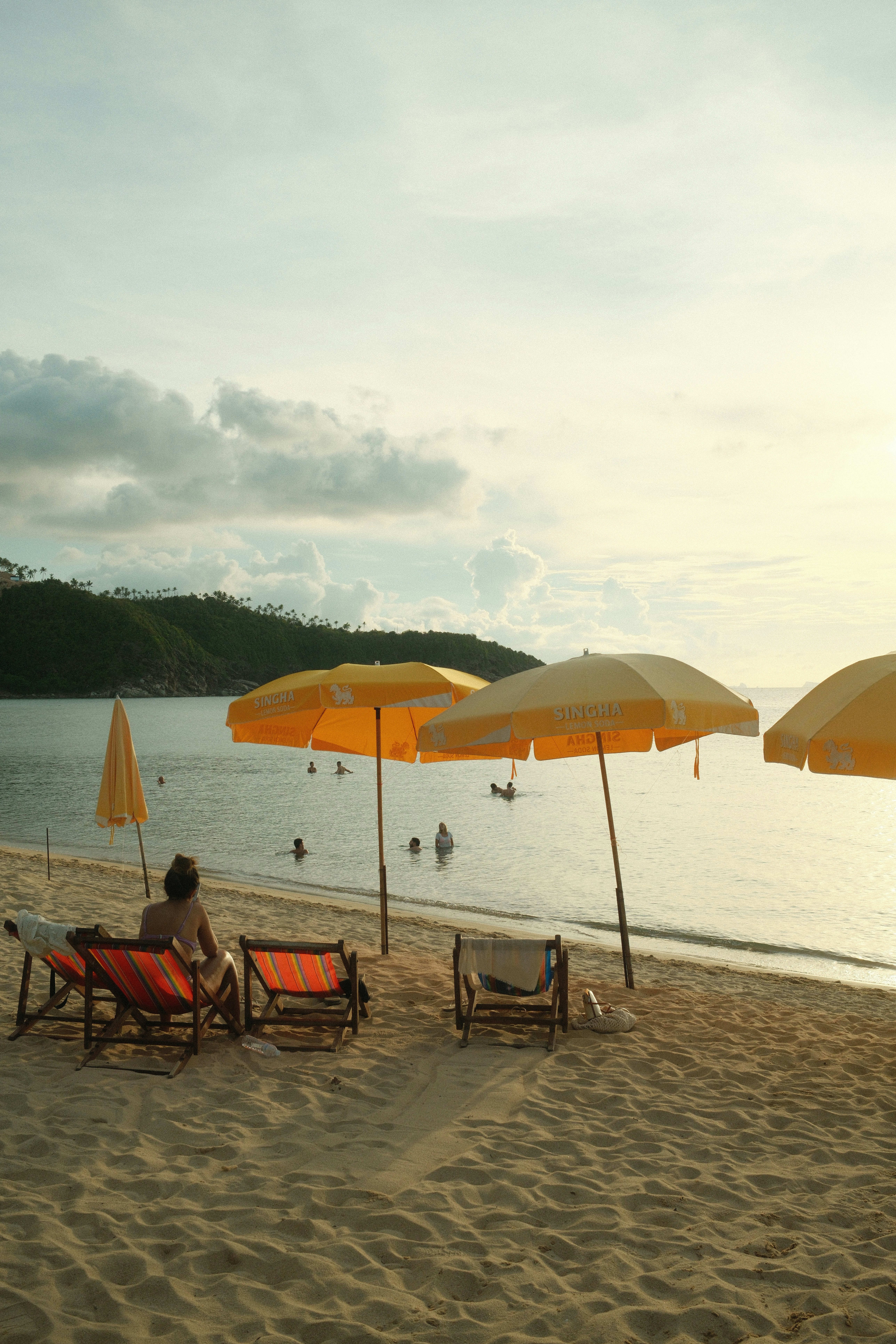 Amber Umbrellas and Quiet Shore: A Golden Hour Beach Portrait