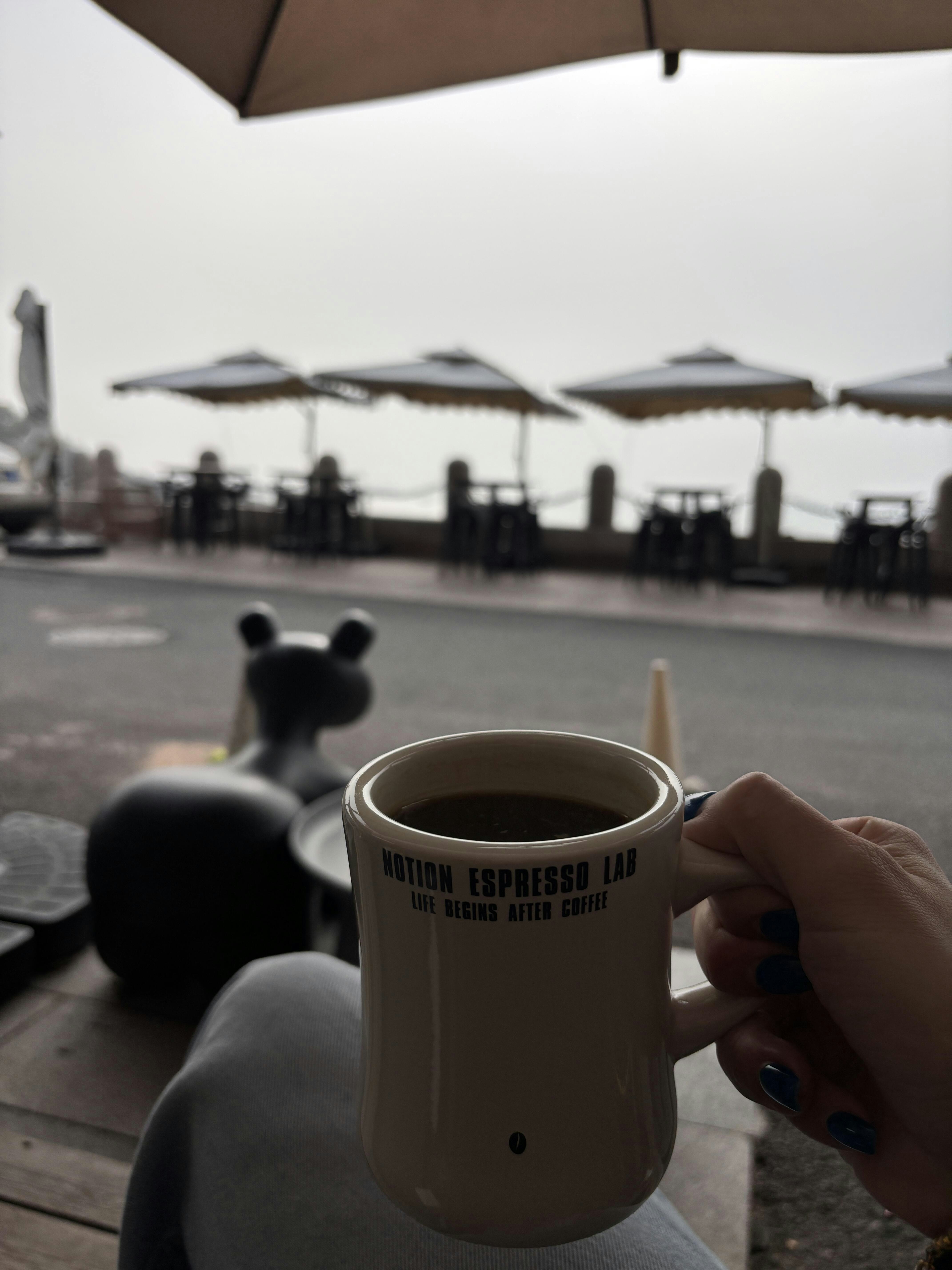 Corner Cup: Sharp Mug, Soft-Blurred Terrace of Umbrellas