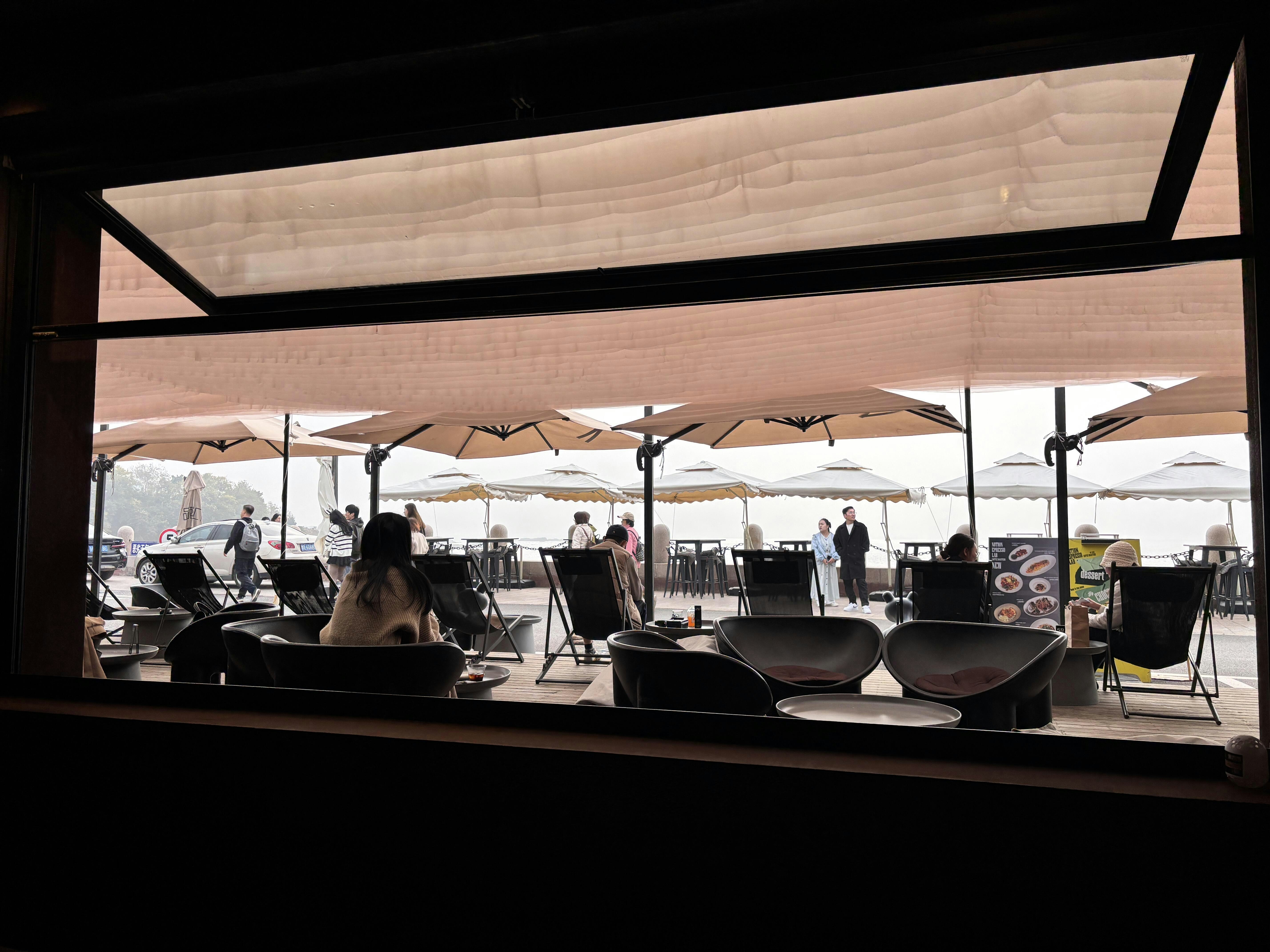 Framed Quiet: A Café Window Overlooking a Sunlit Terrace