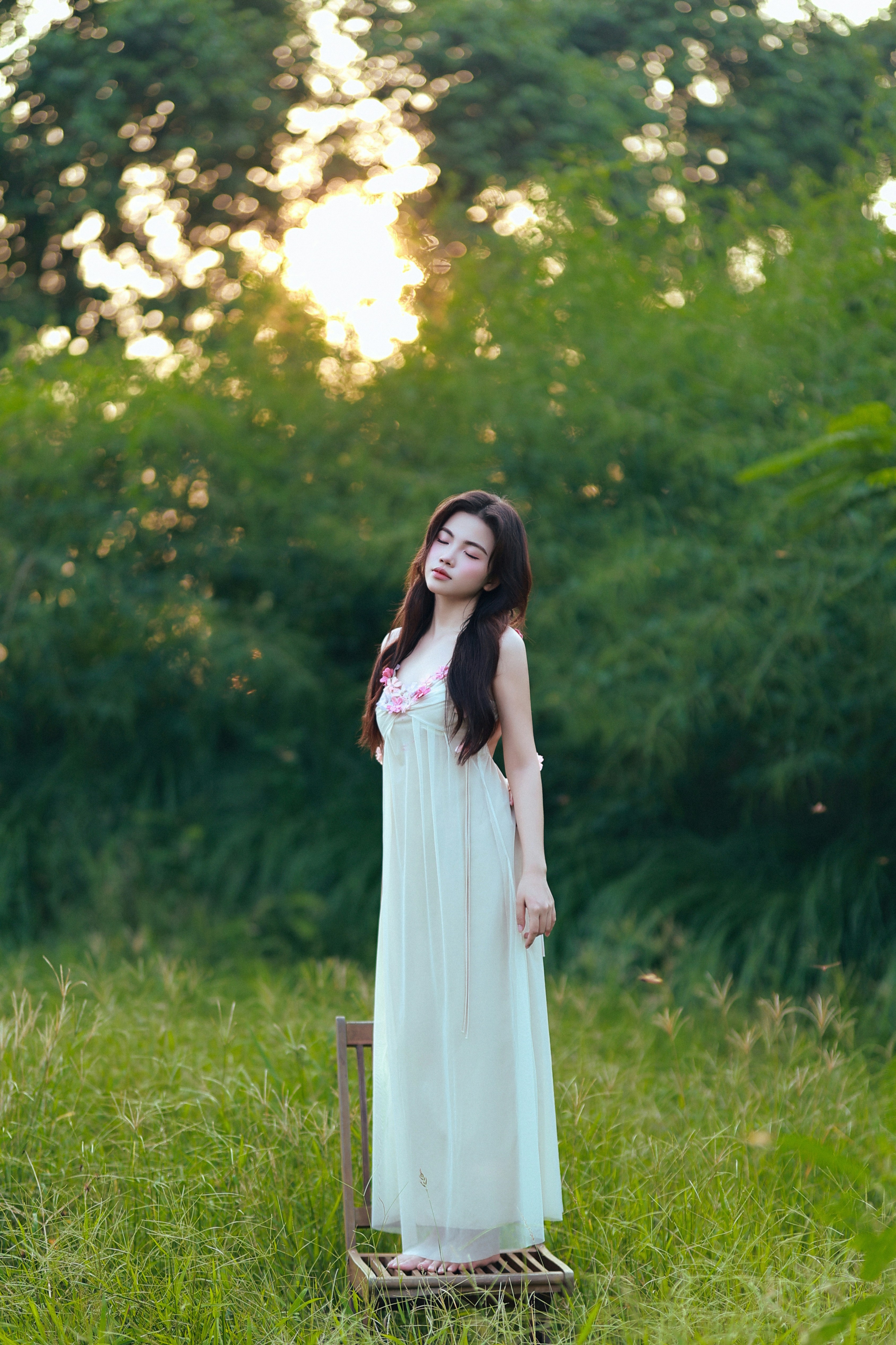 Young woman in a floral dress during golden hour.