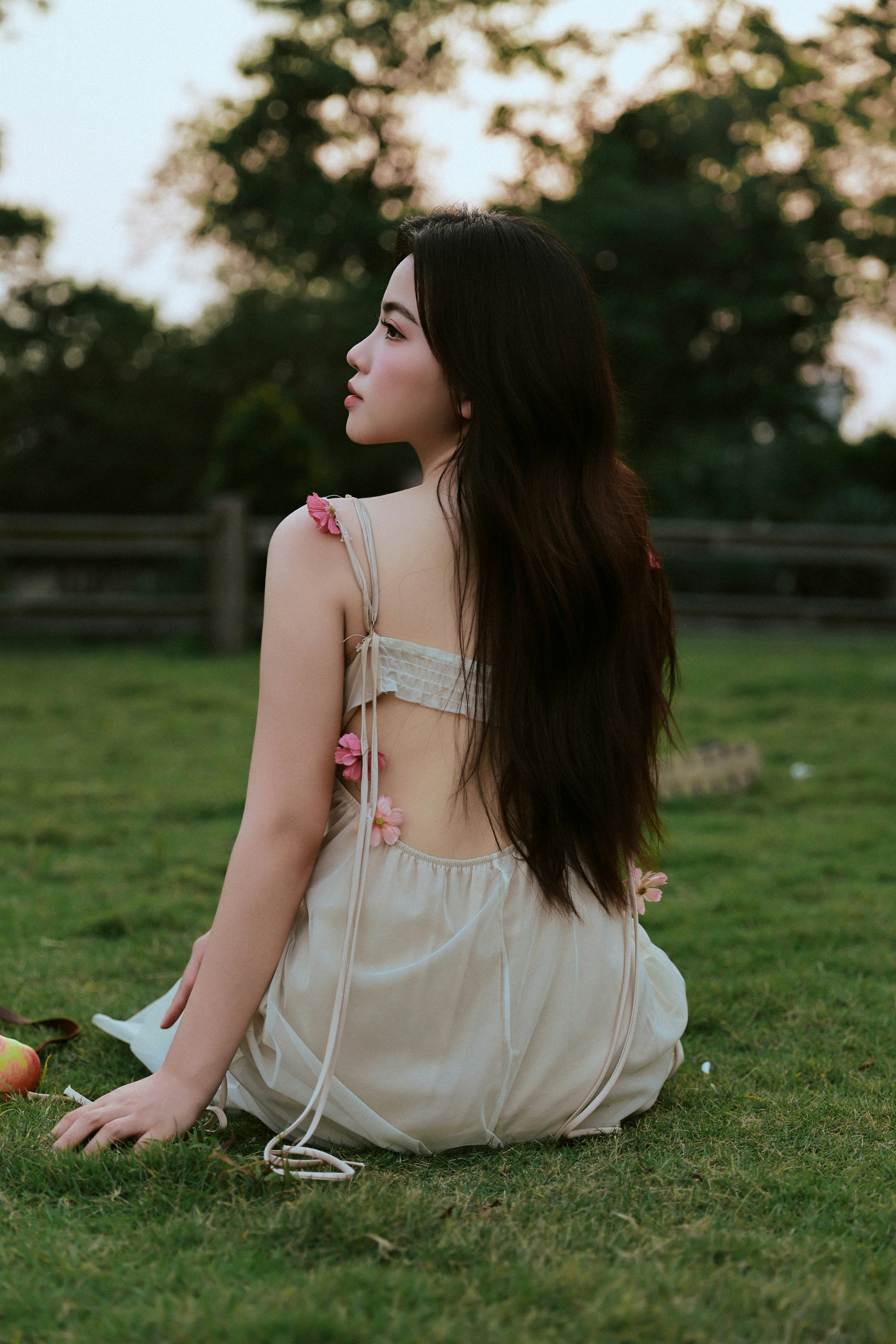 Young woman in a floral dress during golden hour.