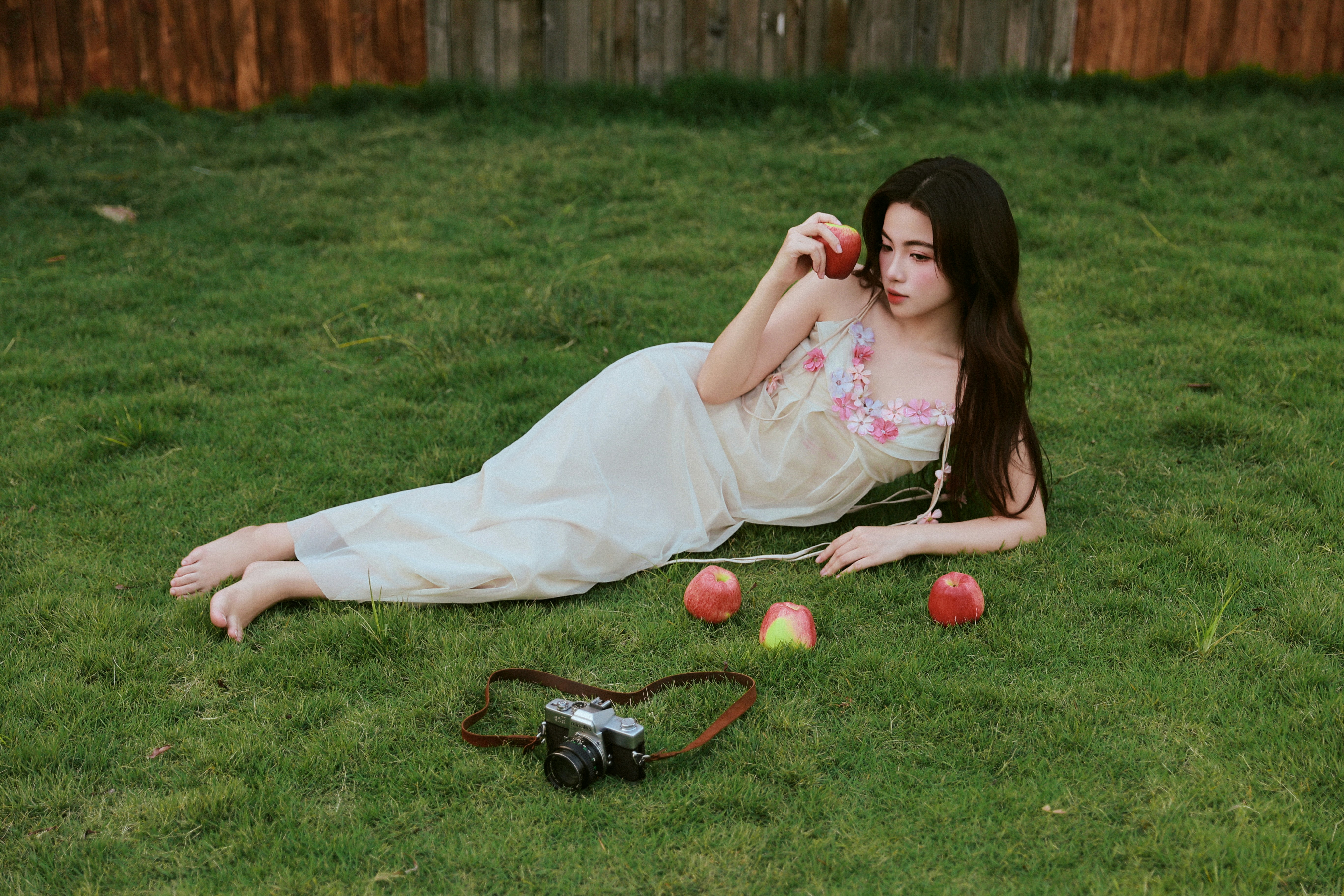 Apple Rest: A Soft Portrait on Grass with a Vintage Camera