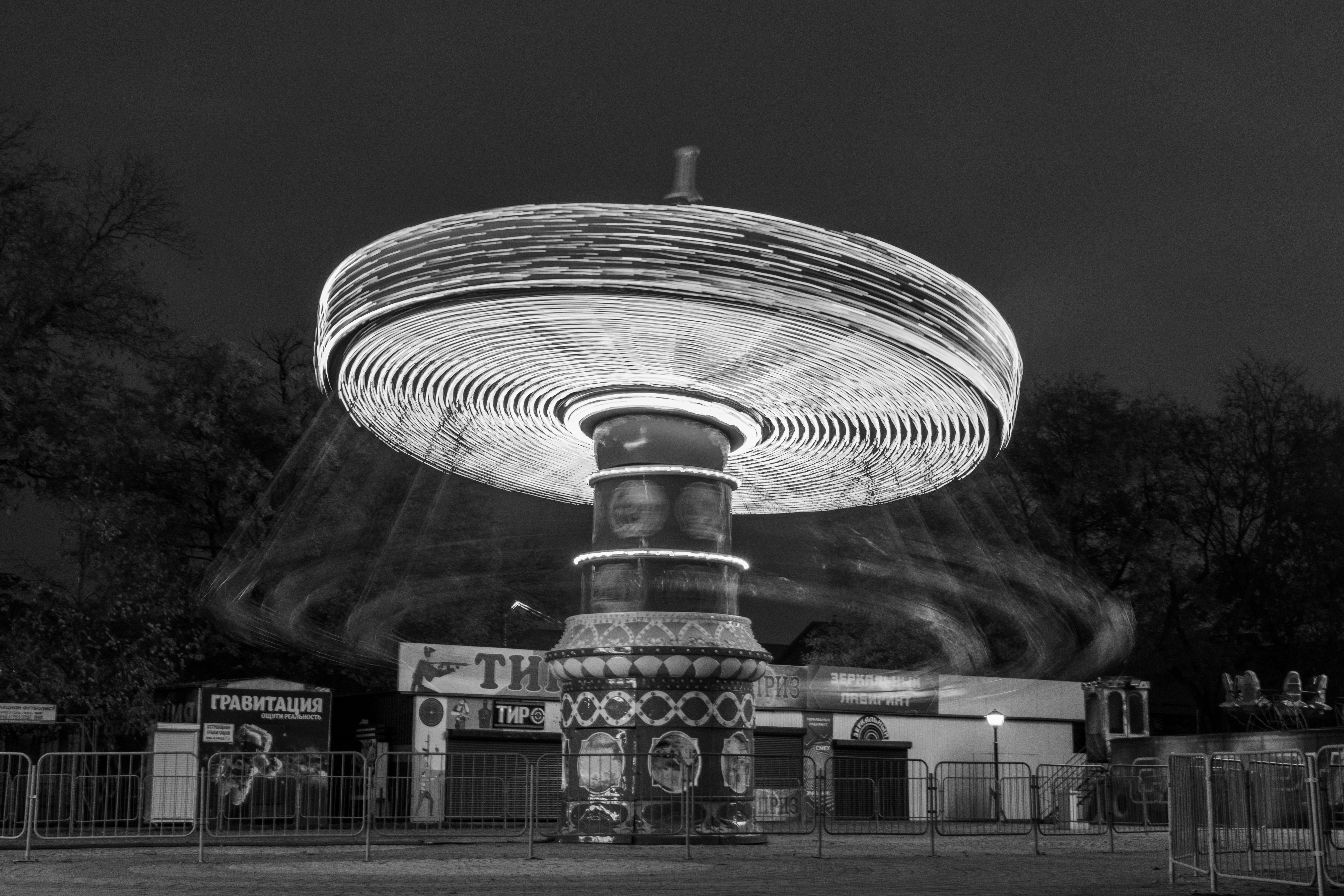 Monochrome Night Spin: A Blurred Carousel Ring Over the Quiet Fair