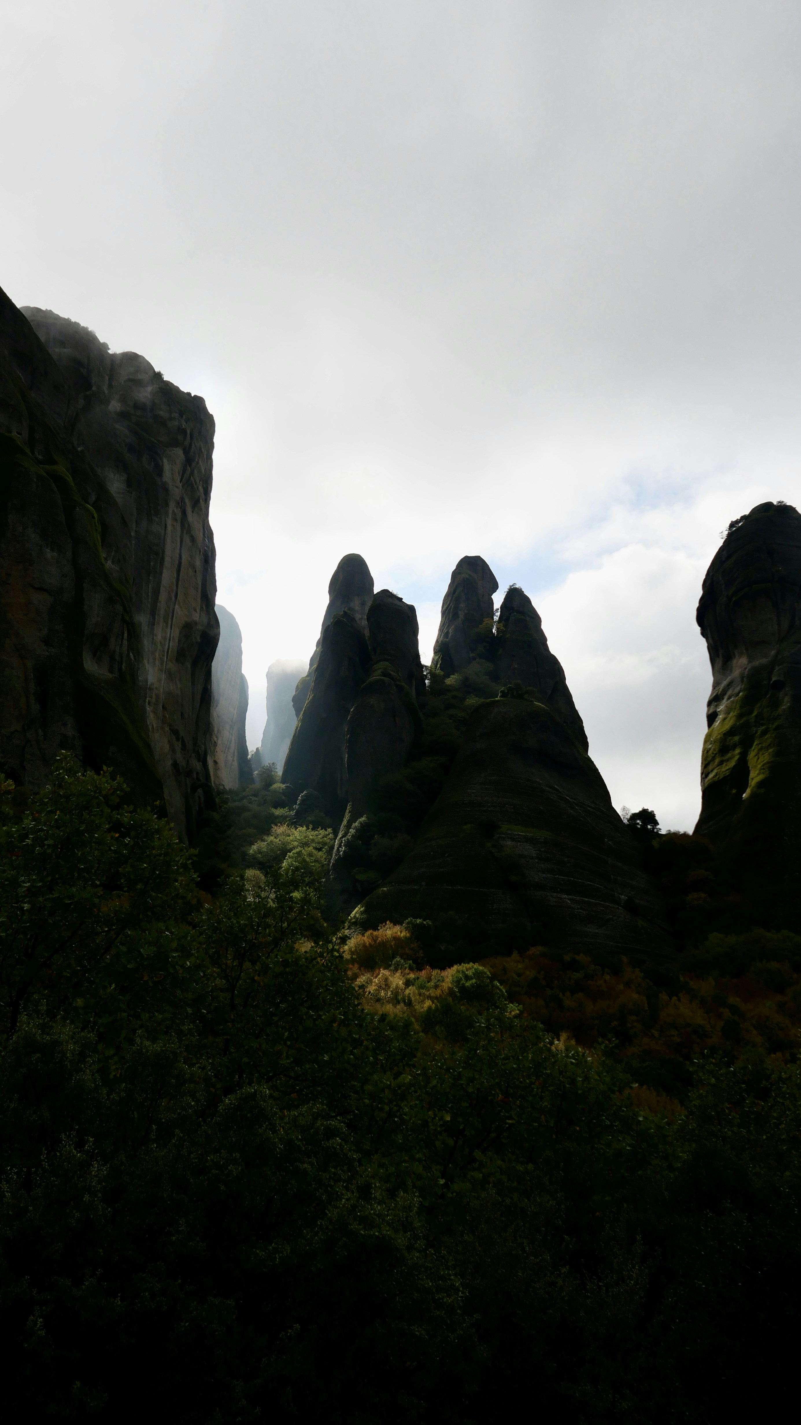 Stone Sentinels Rising Through a Cloud-Pressed Gorge