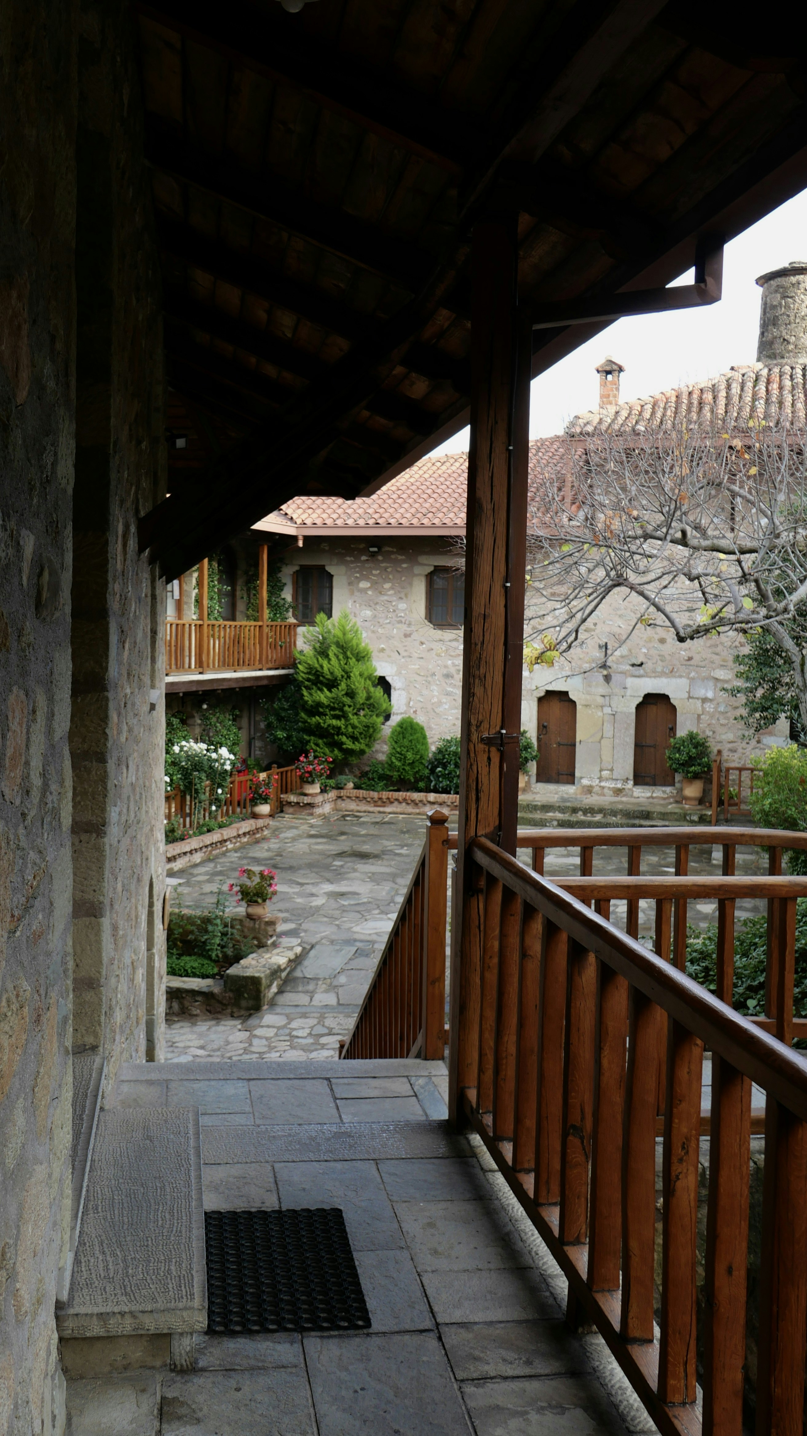 Timbered Veranda Framing a Quiet Stone Courtyard