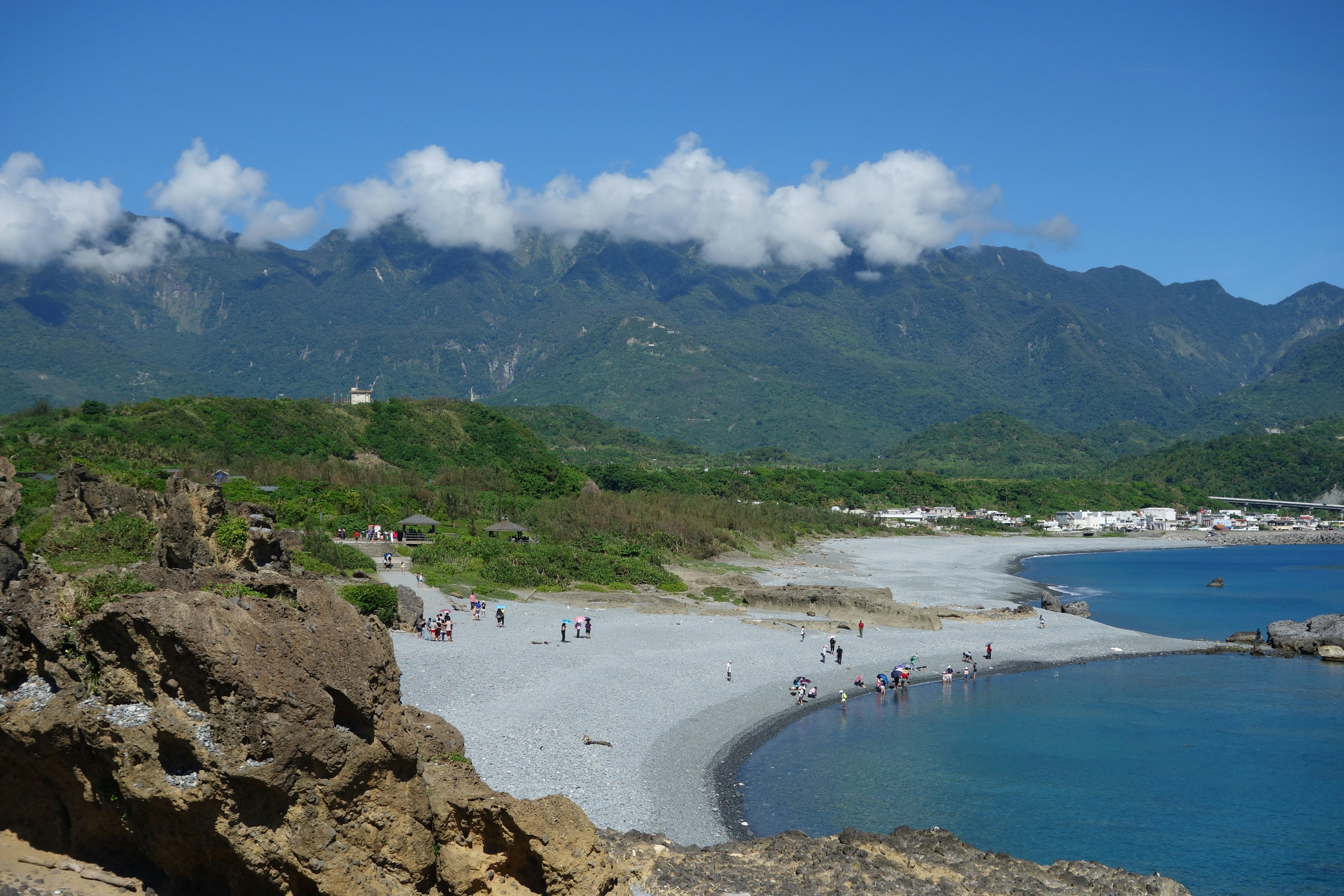 Crescent Beach Beneath Cloud-Wrapped Mountains