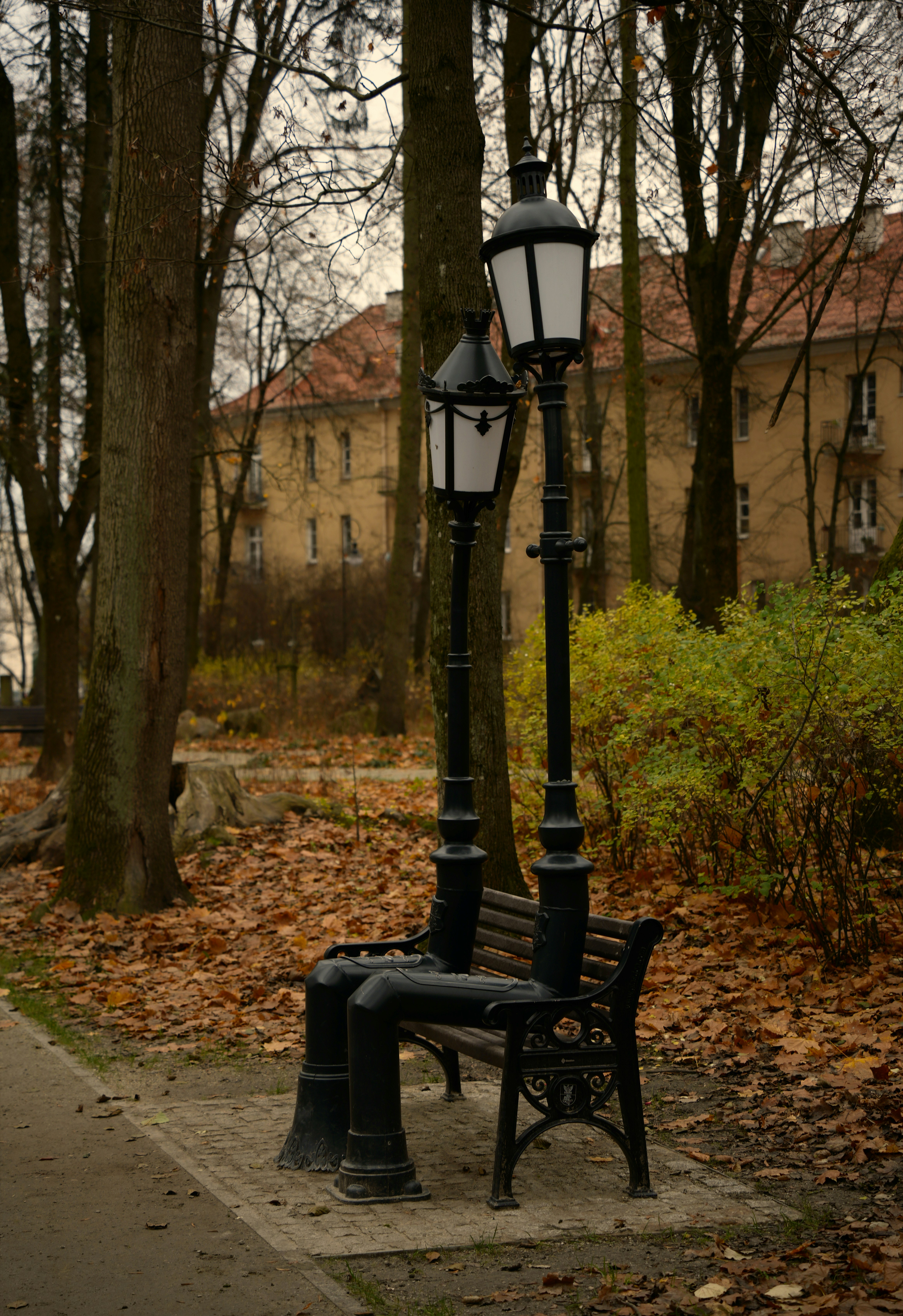 Twin Lanterns as Quiet Sentinels by a Leaf-Littered Park Bench