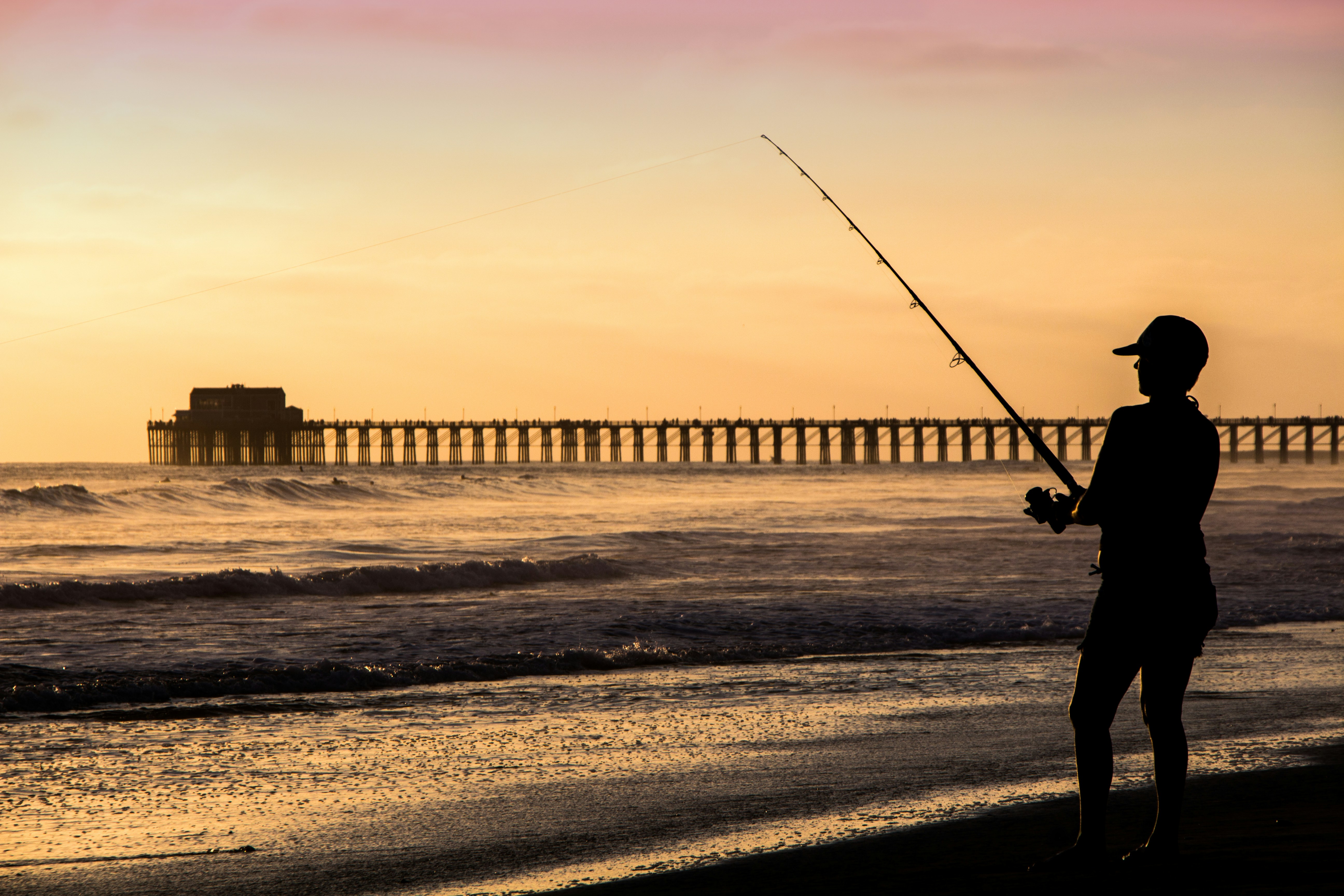 Dusk Cast: Lone Angler Silhouette by a Pier at Sunset