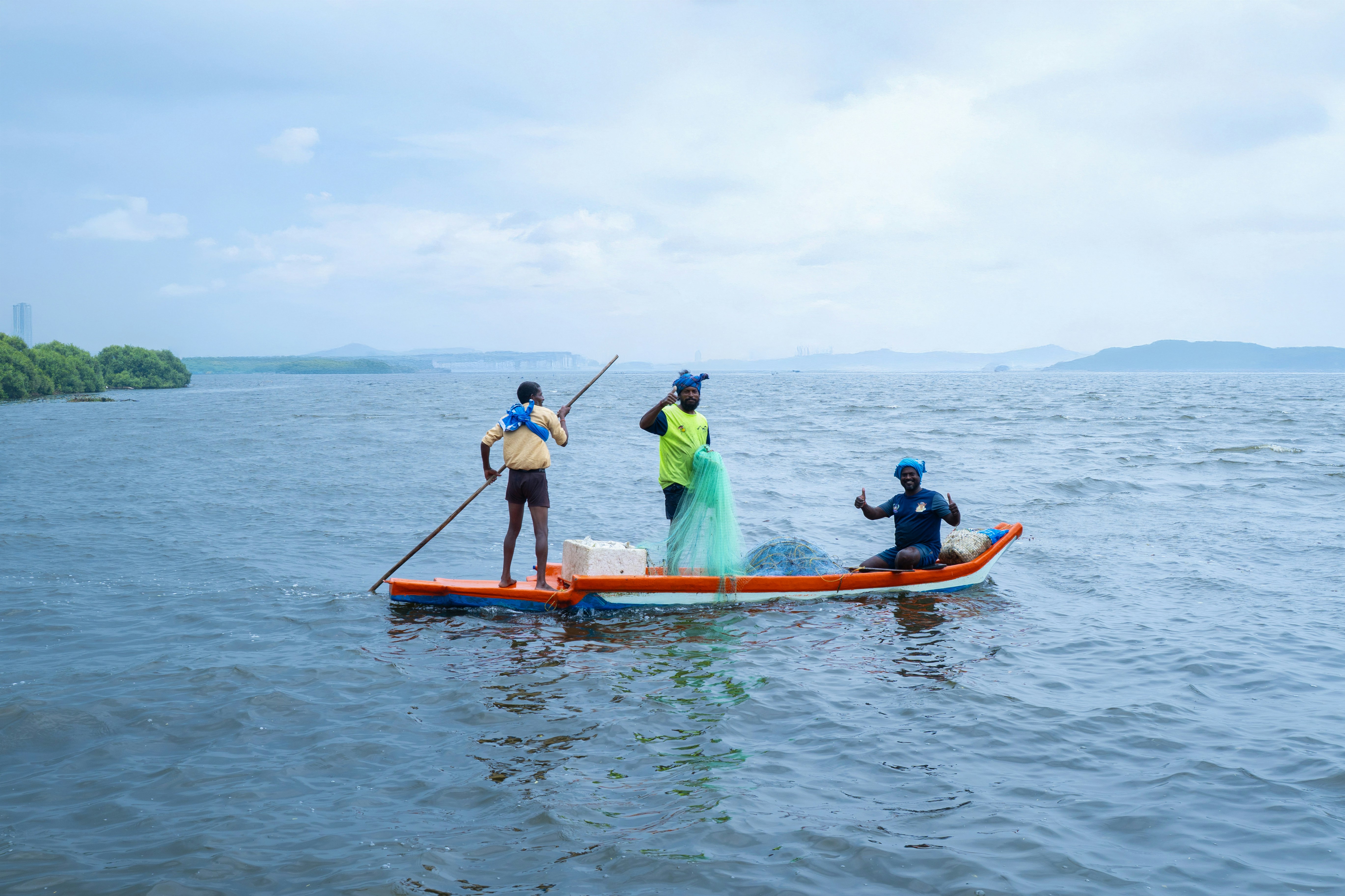 Three fishermen on a boat in the water. photo – Free Sea Image on Unsplash