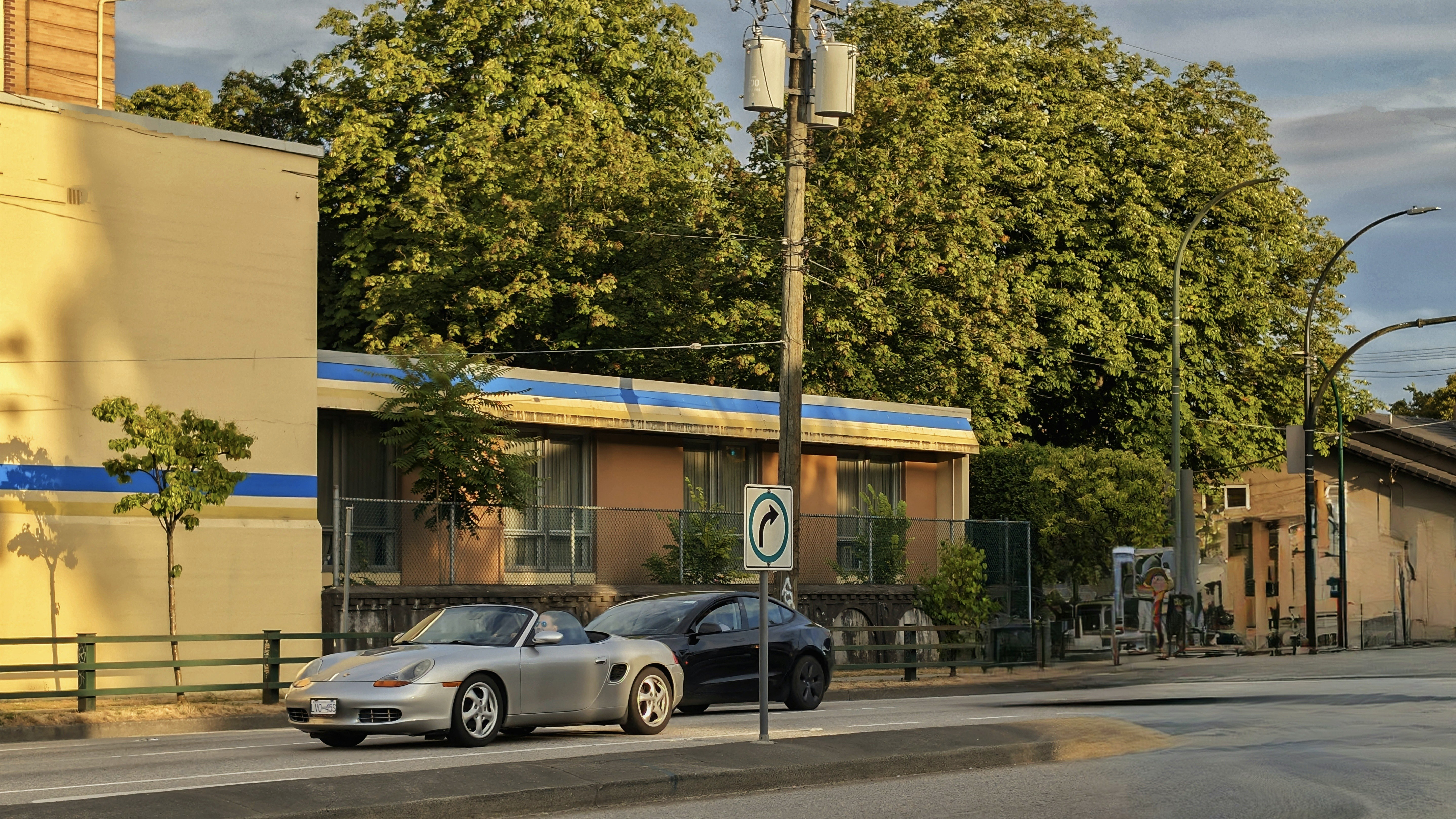 Golden Hour Stop: A Silver Coupe Framed by a Quiet Street Corner