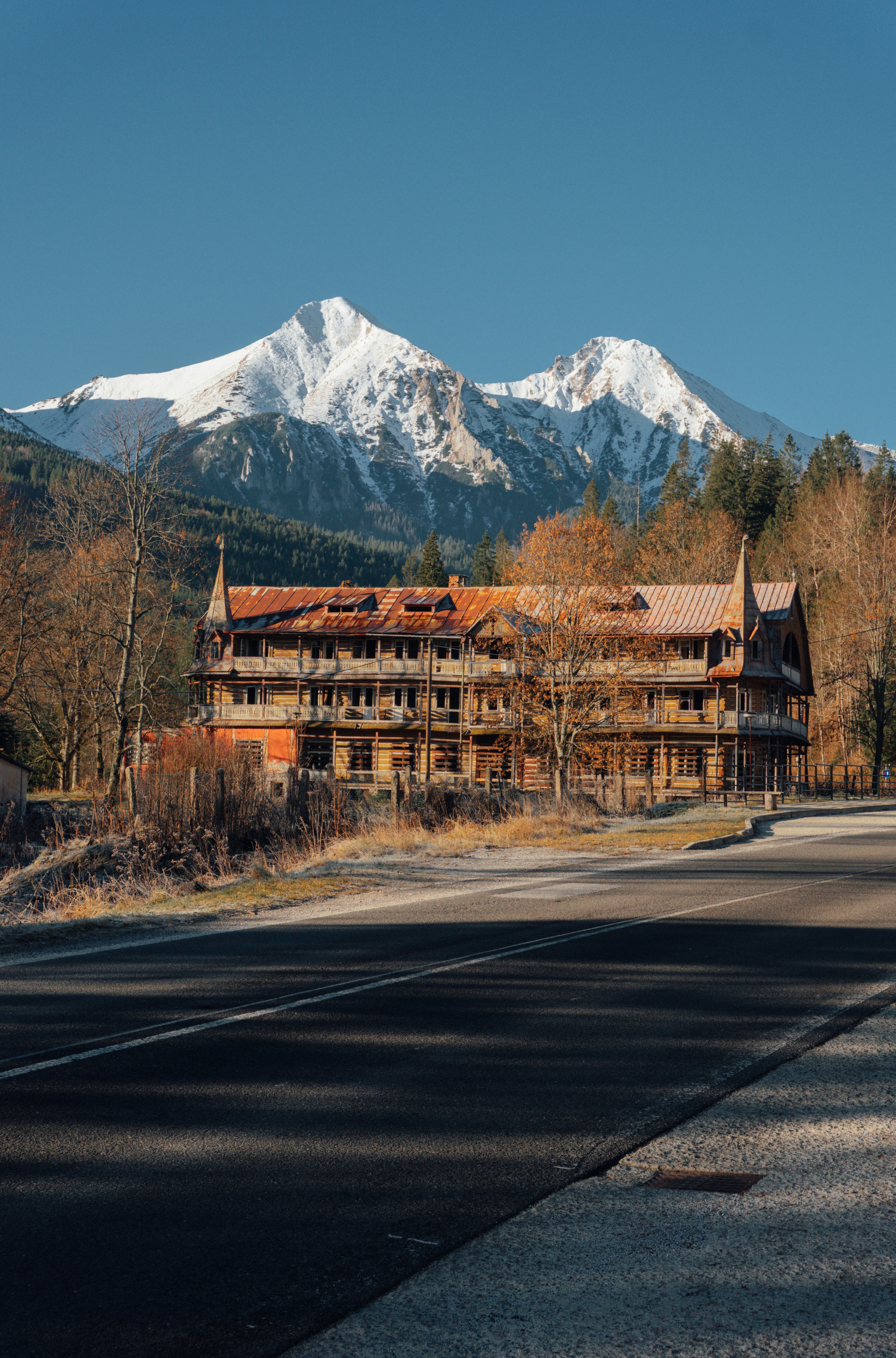 Rust-Striped Lodge Framed by Snow-Capped Peaks