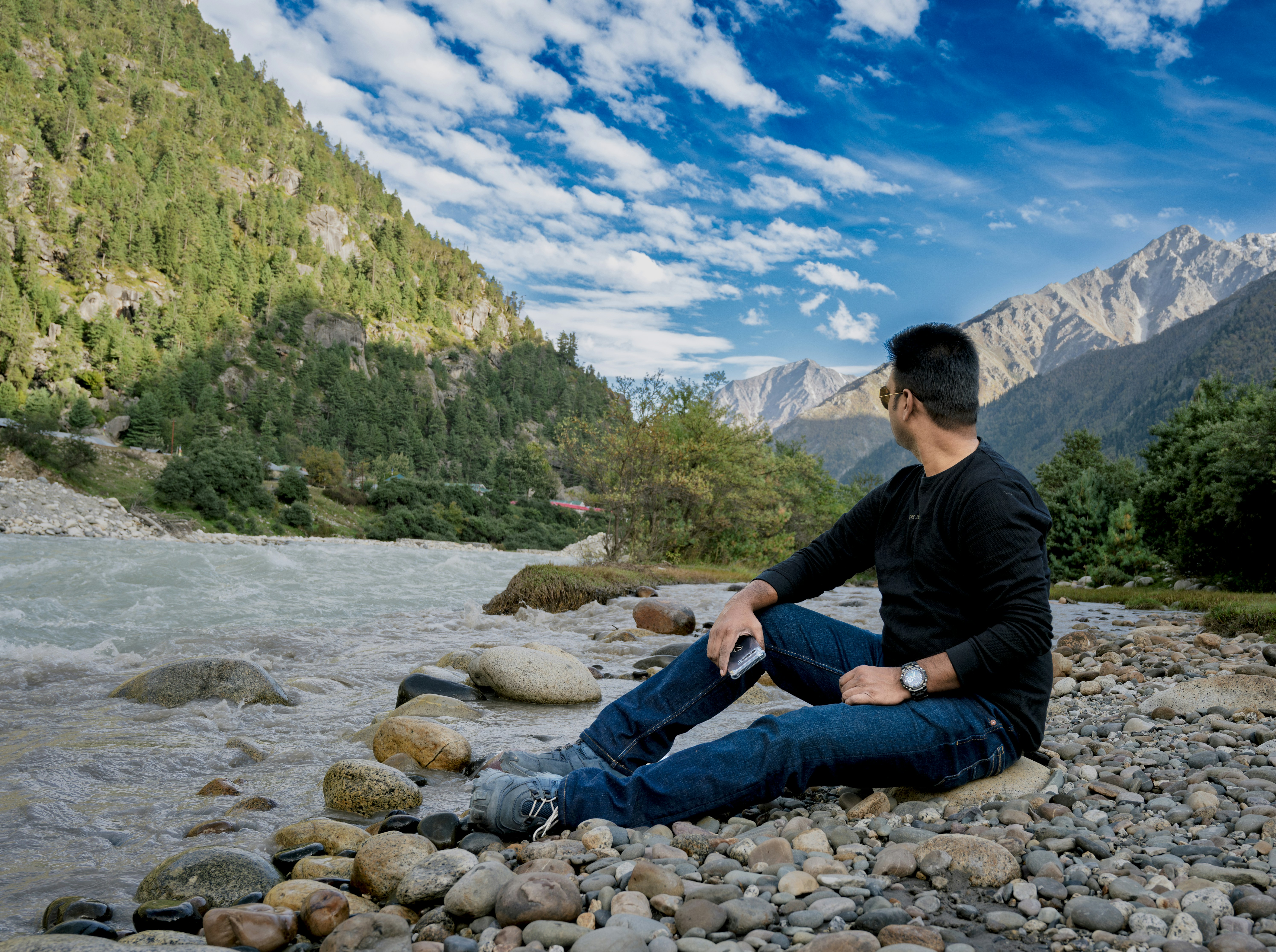 Alpine Riverbank Moment: Quiet Presence Among Granite and Sky