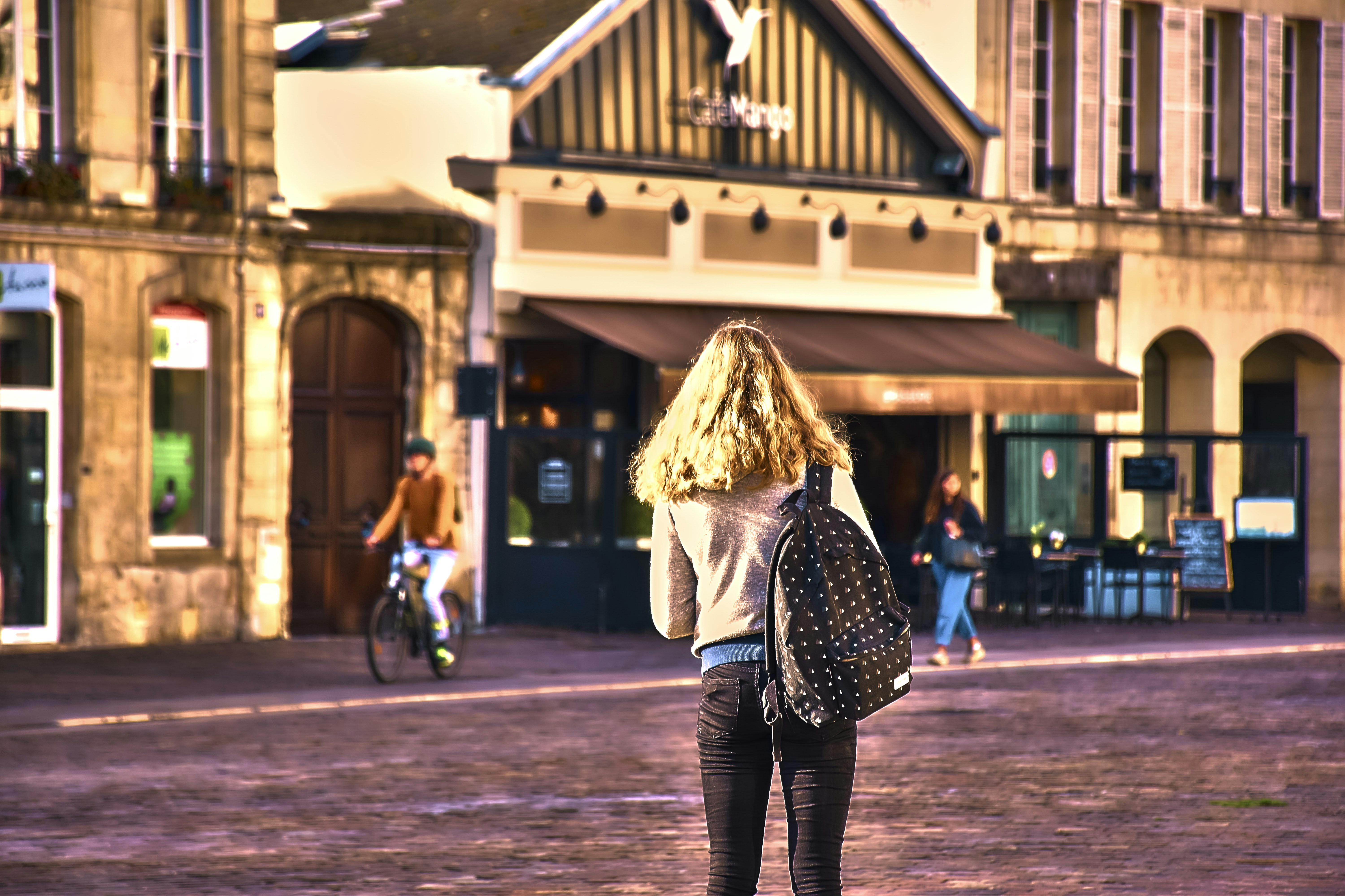 Polka-Dotted Backpacker in a Sun-Warmed European Square