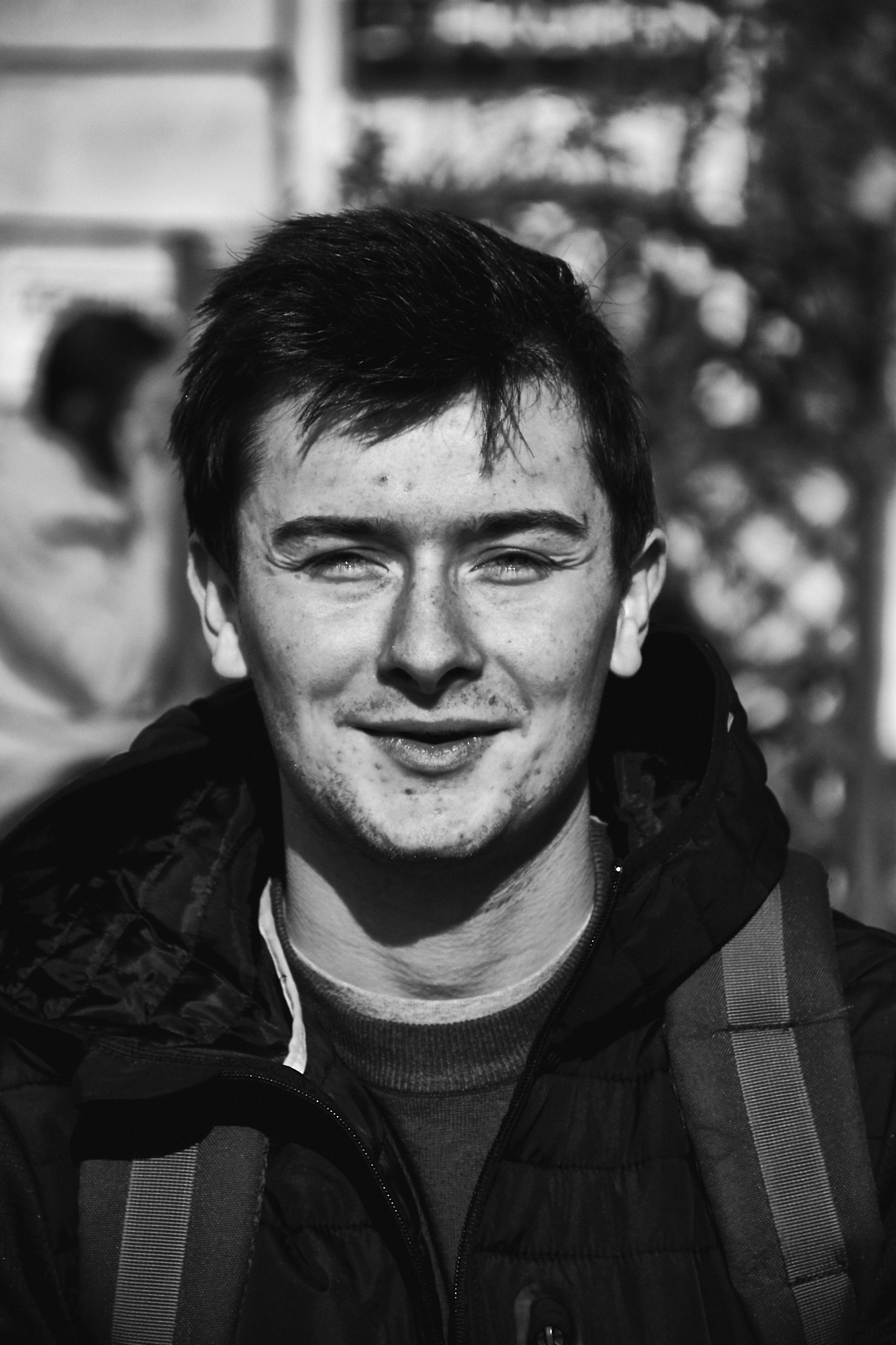Grayscale Gaze on Campus: A candid outdoor portrait with a warm smile