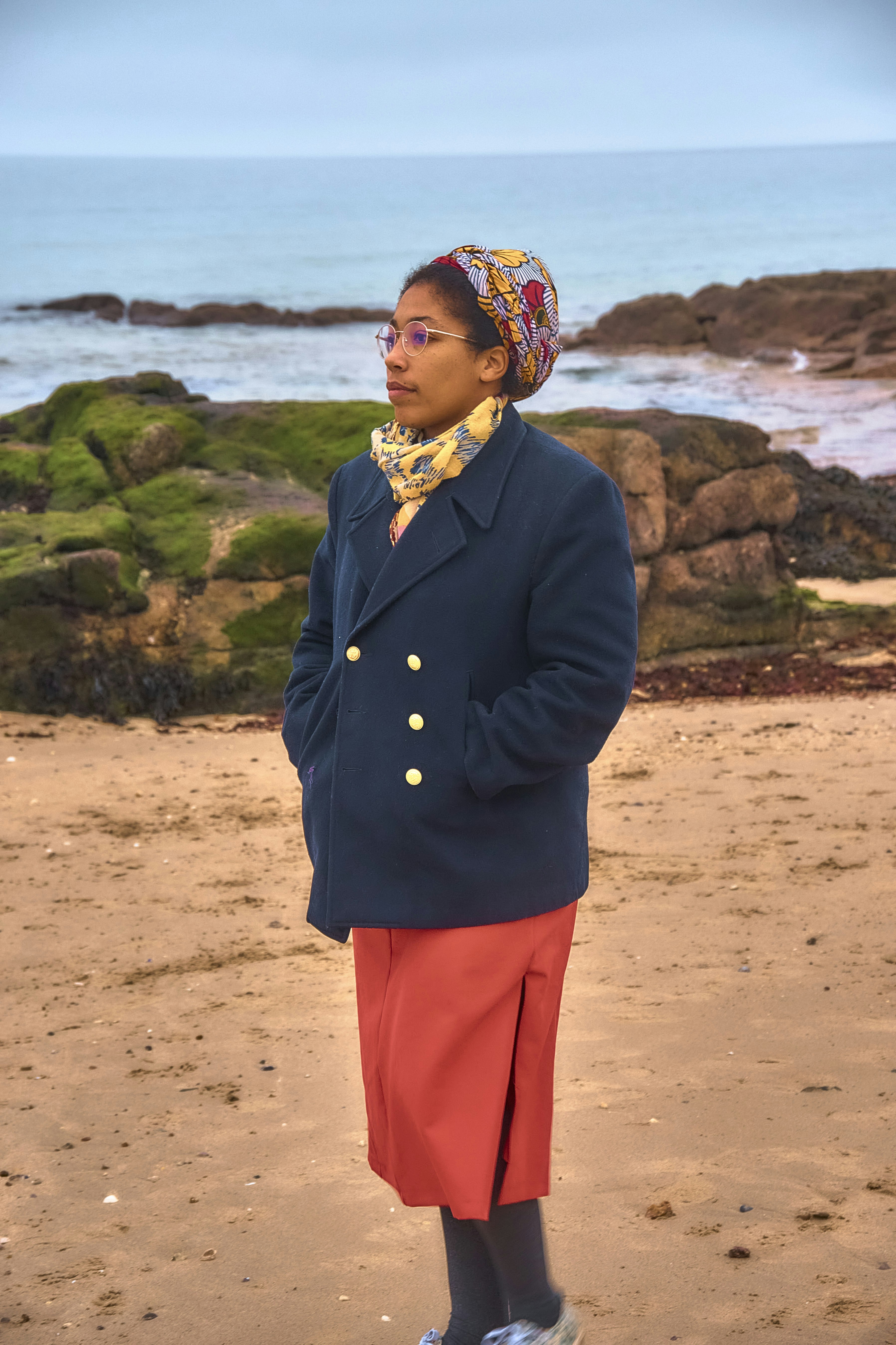 Seaside Portrait in Color: A Coastal Stylist Stands Against Mossy Rocks
