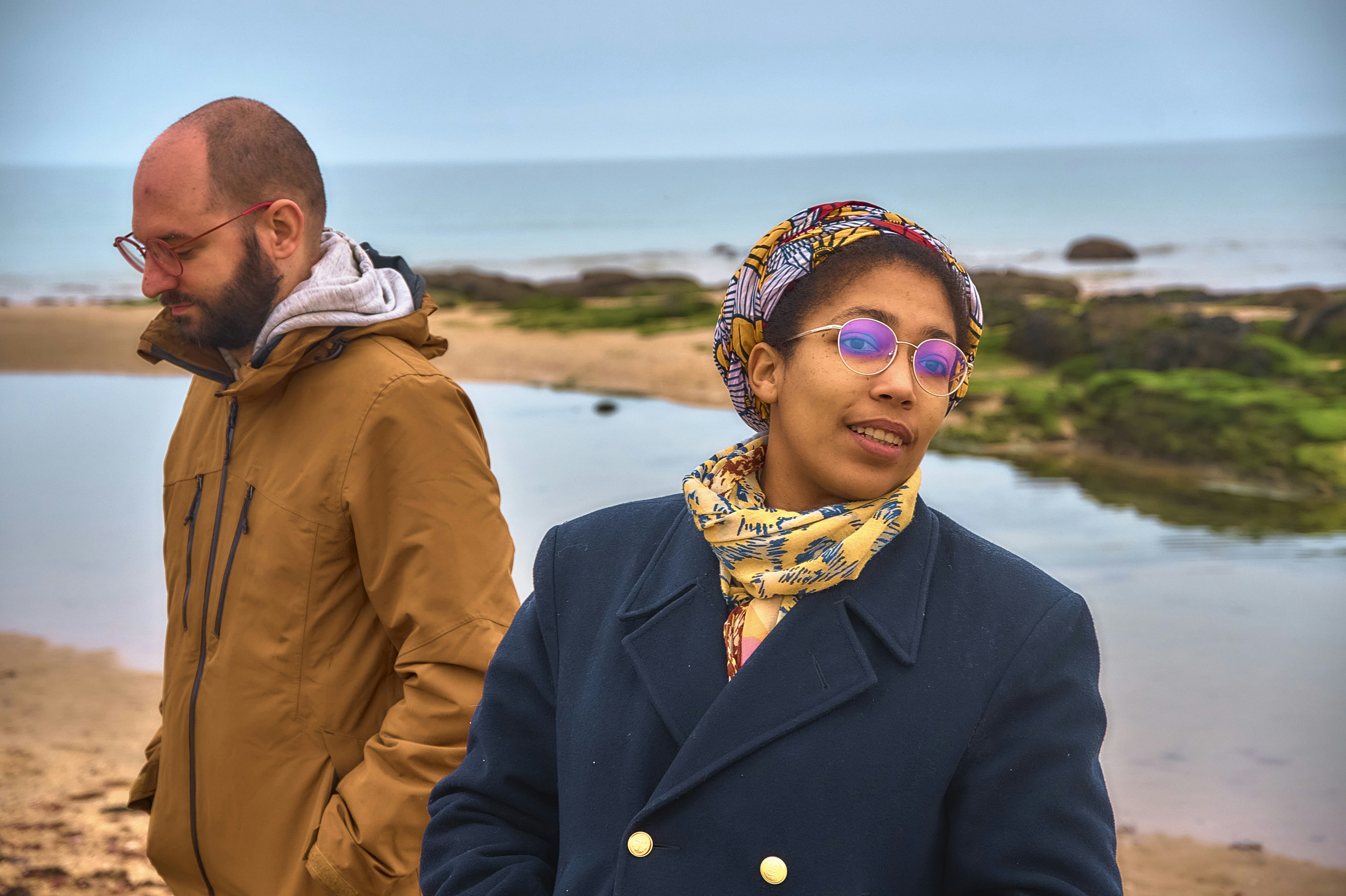 Coastal Portrait in Color: A Headscarfed Navy-Coat Moment on a Windy Beach