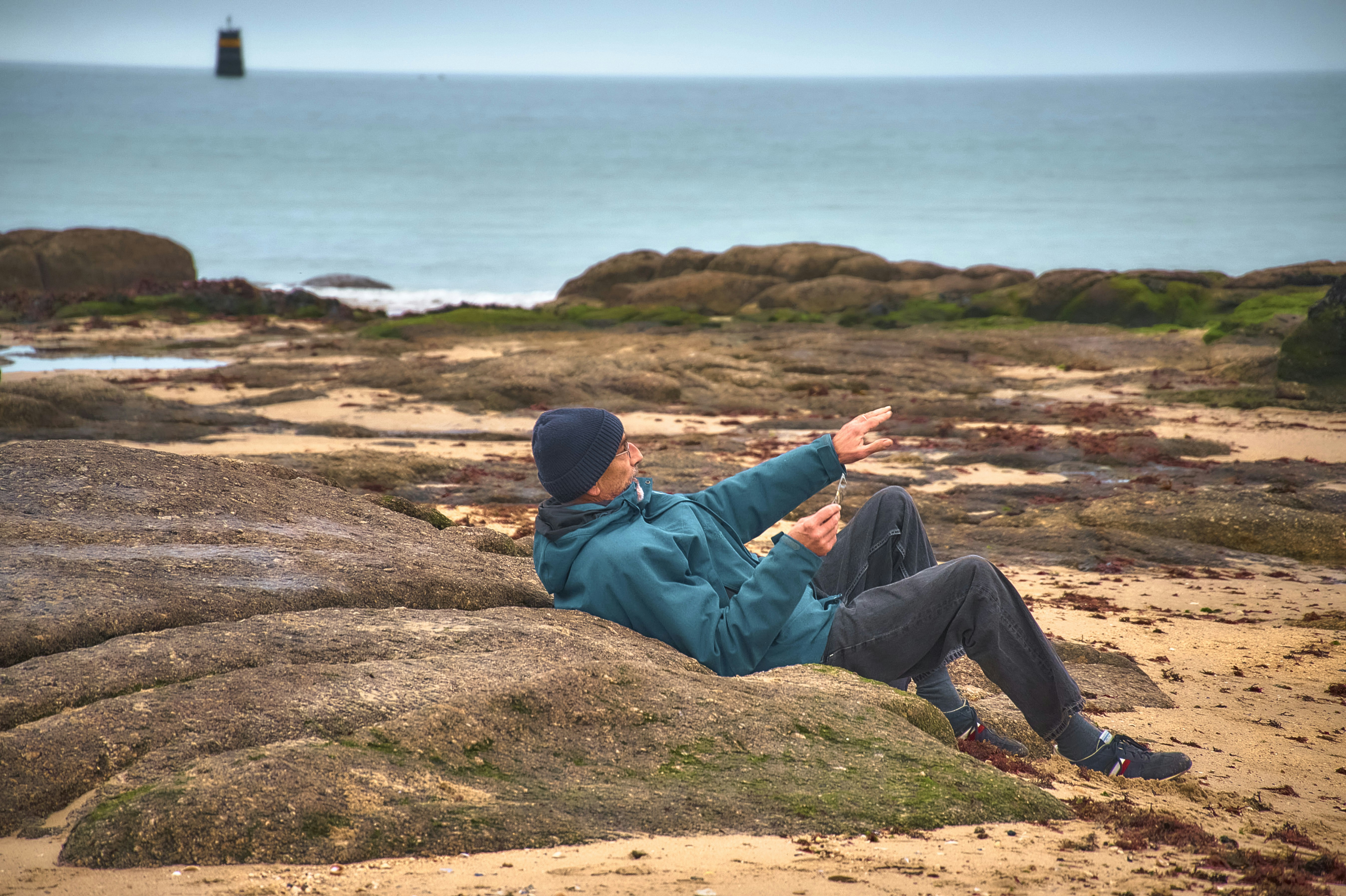 Coastal Recline: A Quiet Moment on Mossy Rocks by the Sea