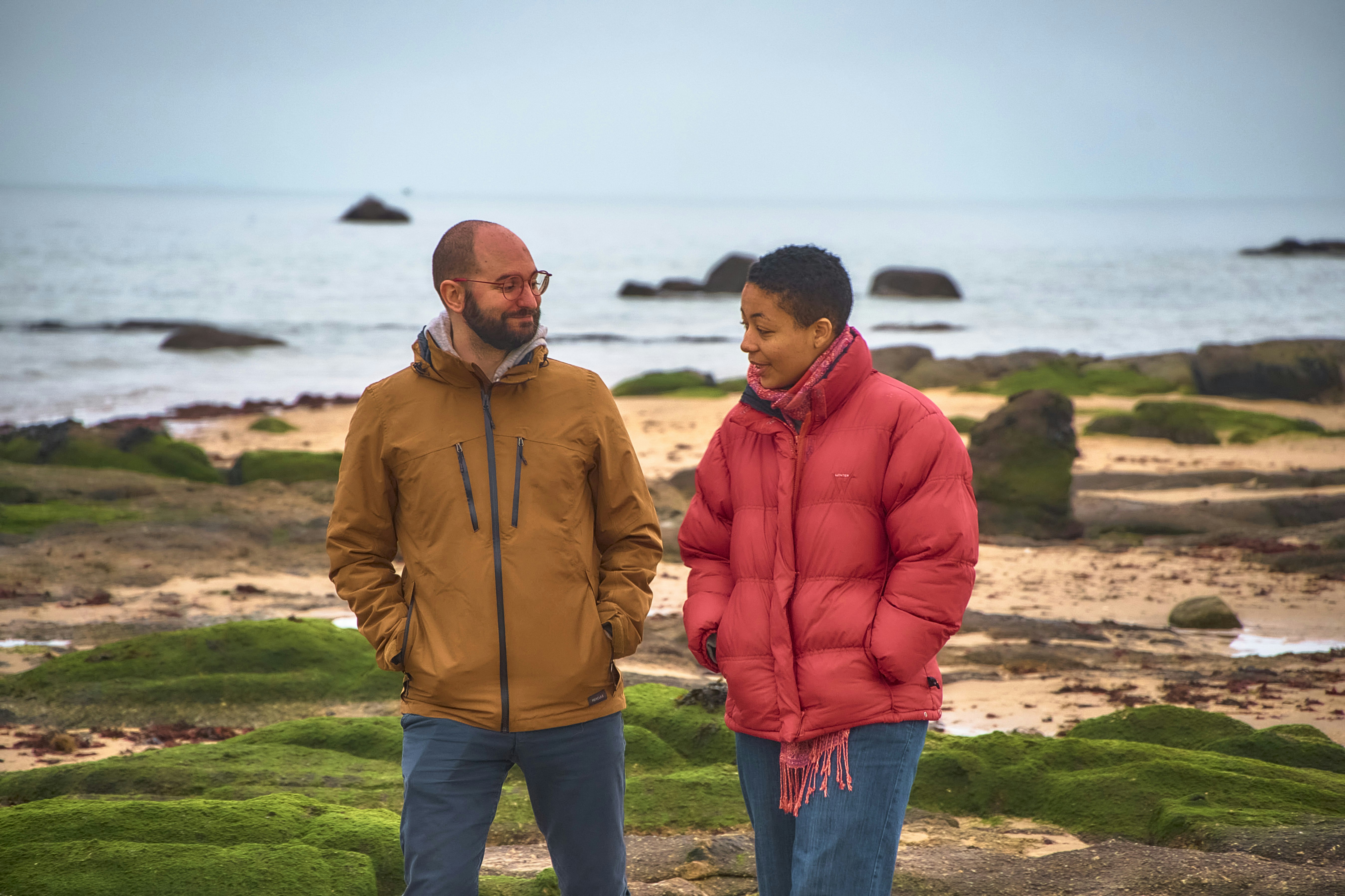 Coastal Conversation: Two Friends in Color on Mossy Shore