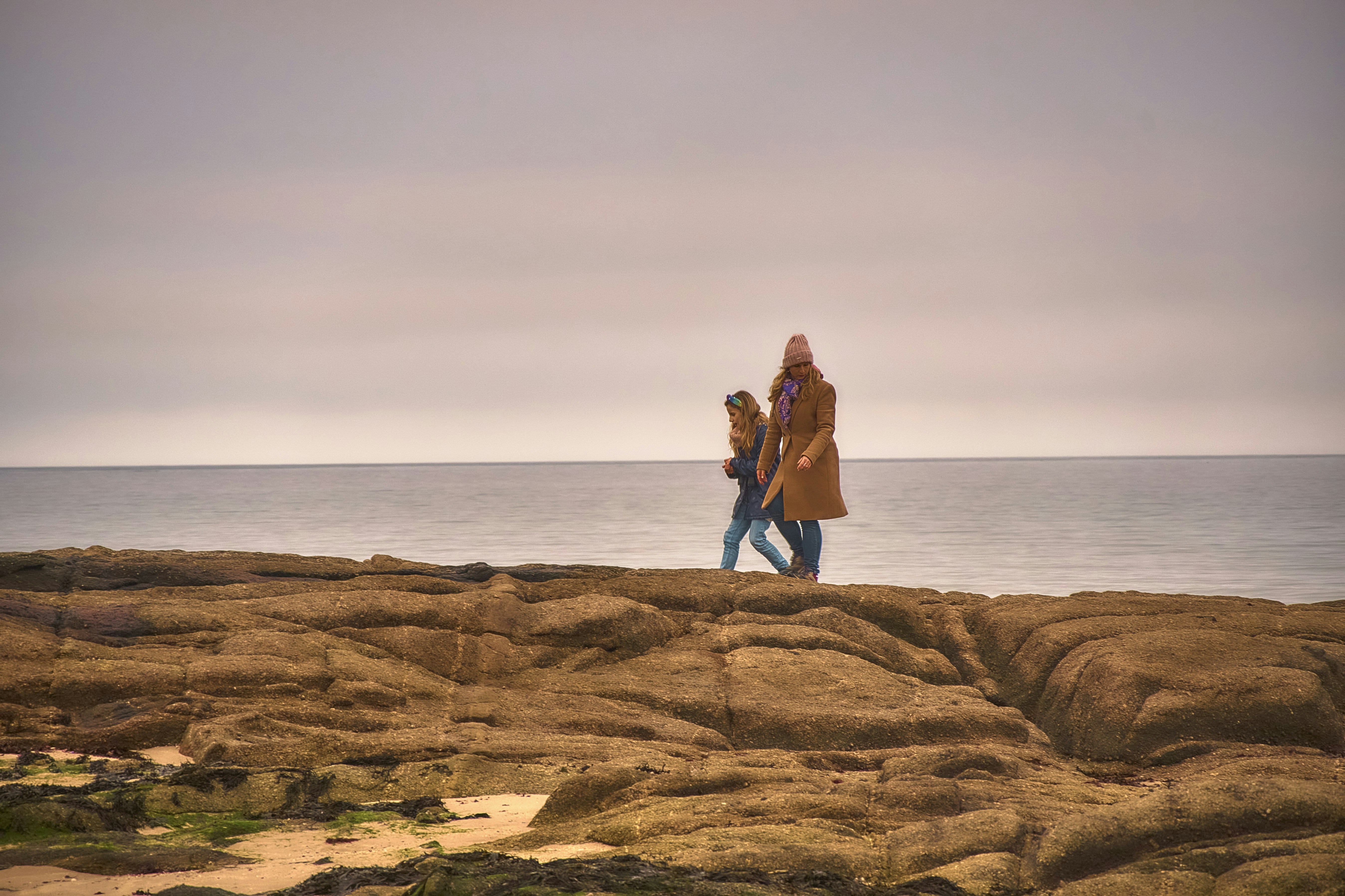Two Figures on a Weathered Seaside Ridge at Dusk