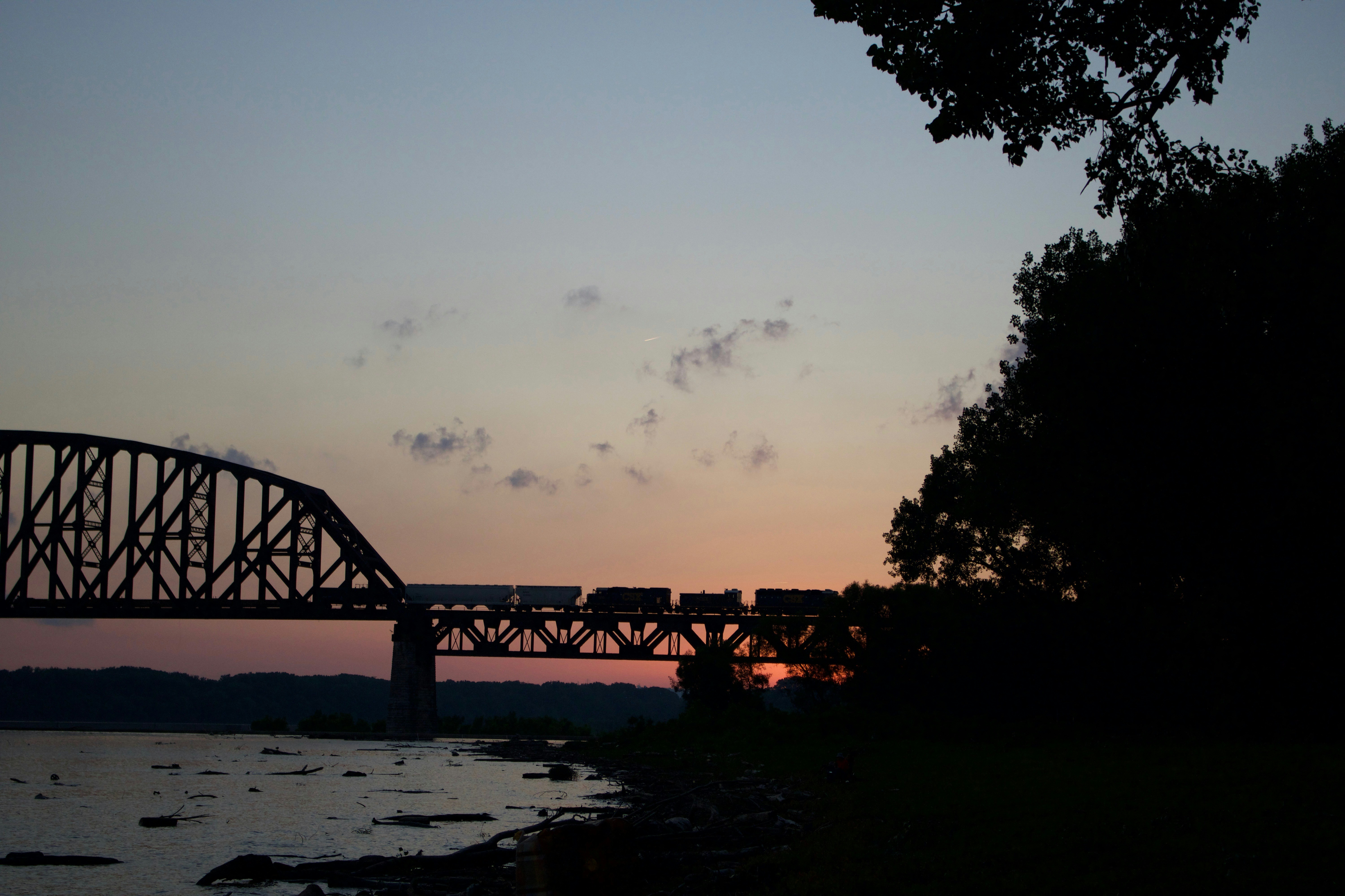 Twilight Span: Silhouetted Truss Bridge Over a Quiet River