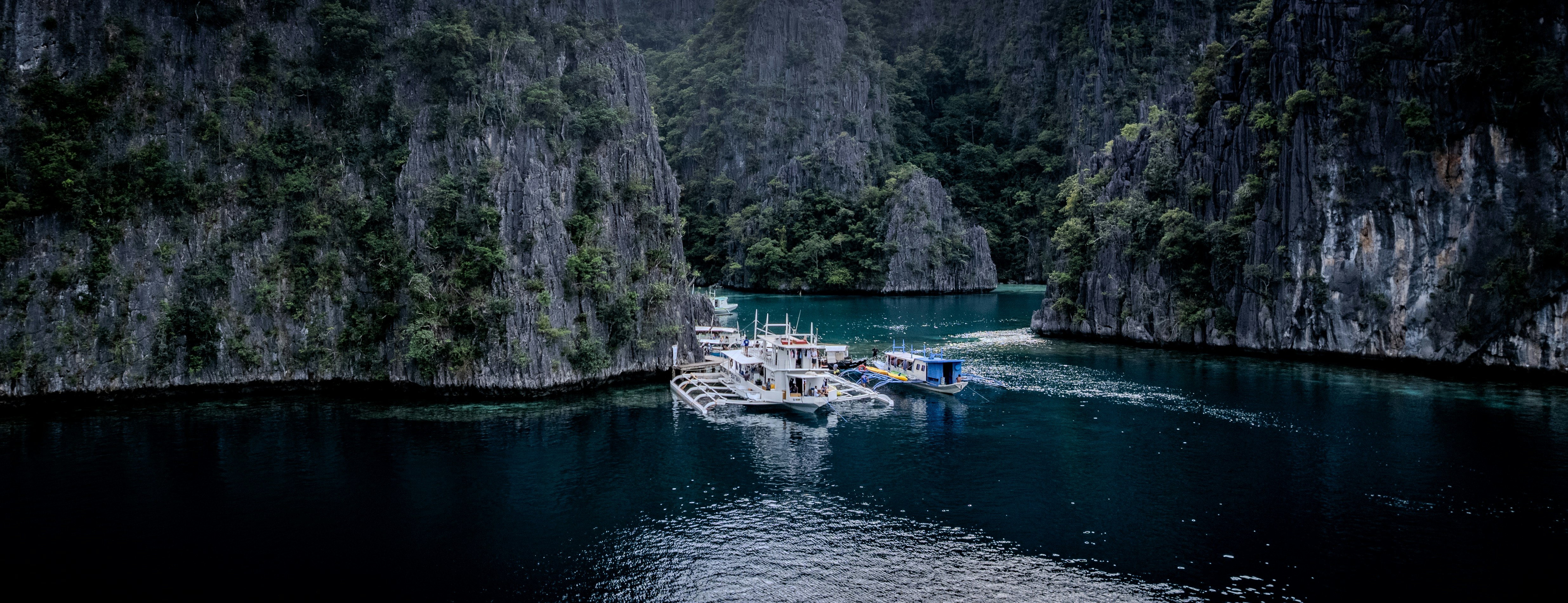 Fjordside Marina: White Boats Nestled Between Limestone Walls