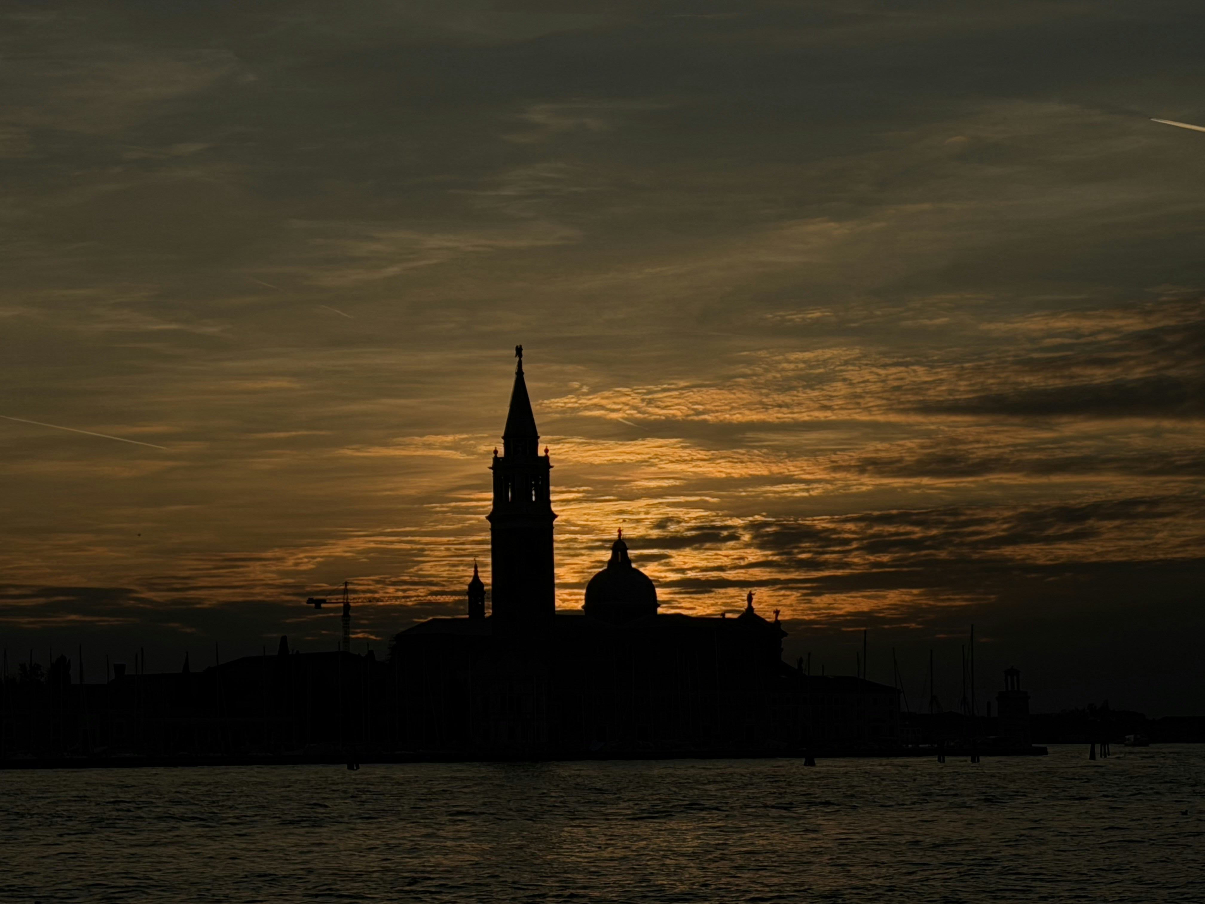 Golden Hour Silhouette: Cathedral Spire Over a Calm Waterfront