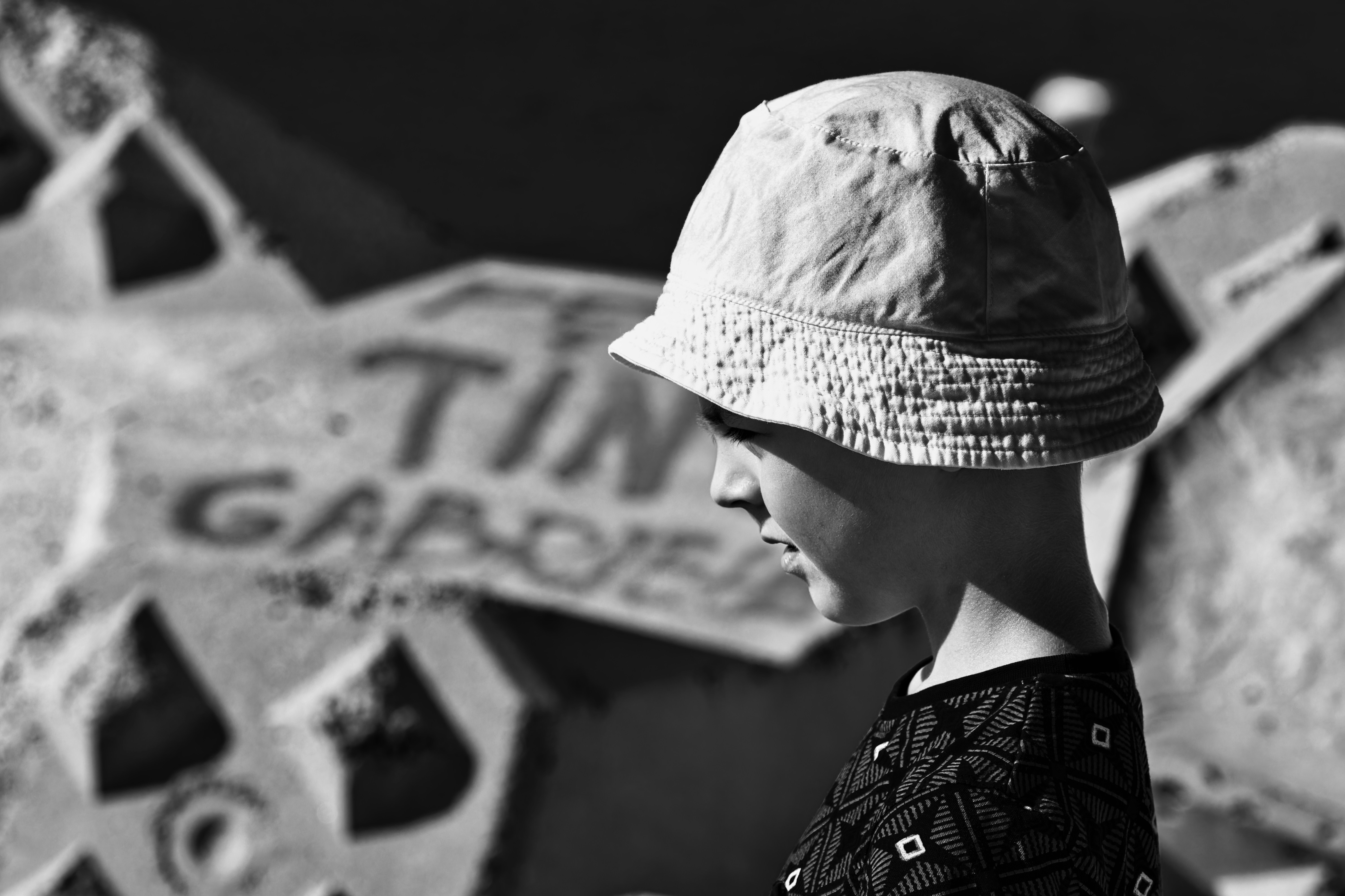 Profile Against Graffiti: A Quiet Moment with a Bucket Hat
