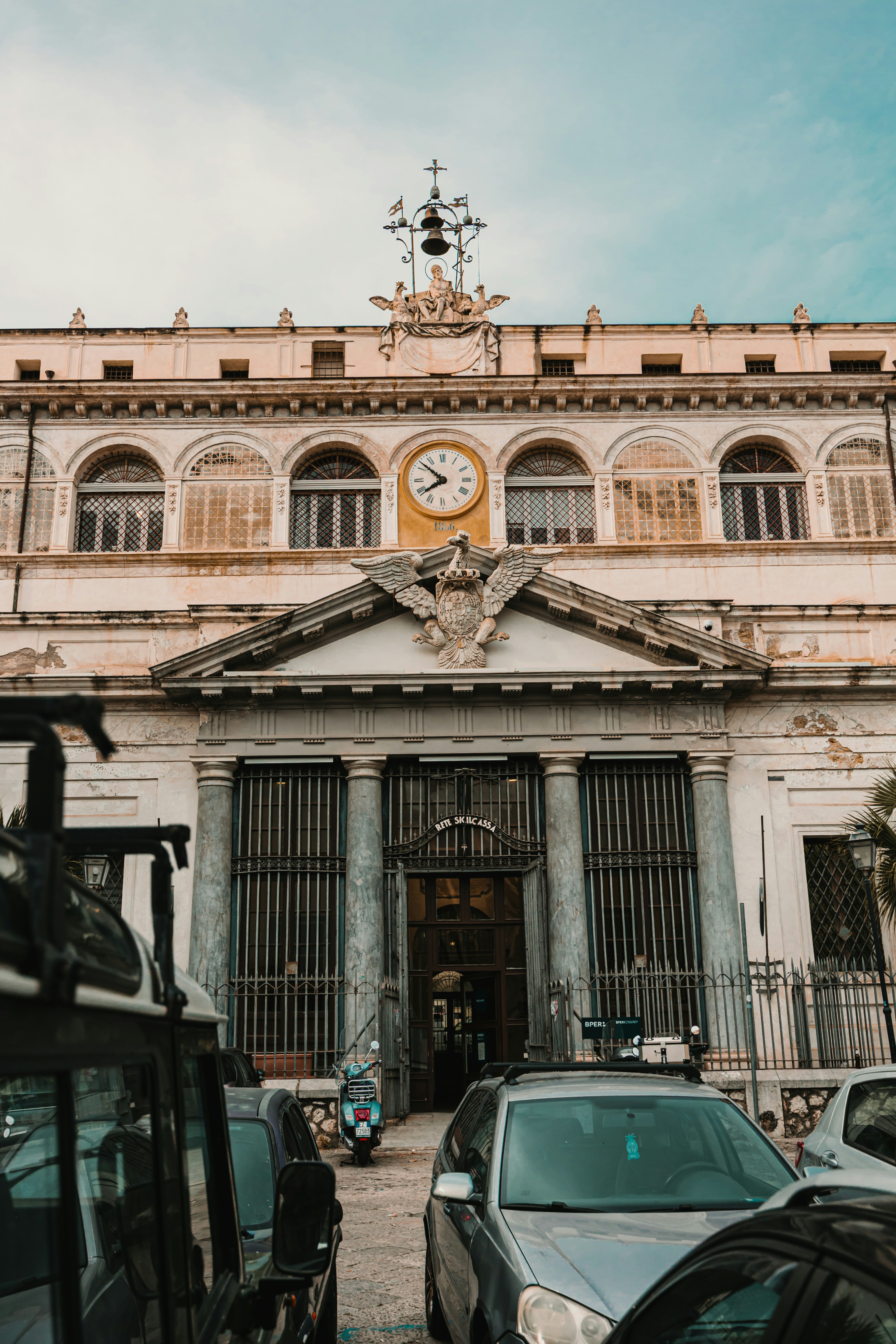 Clock-Crowned Gatehouse: Time-Worn Marble Under a Stately Facade