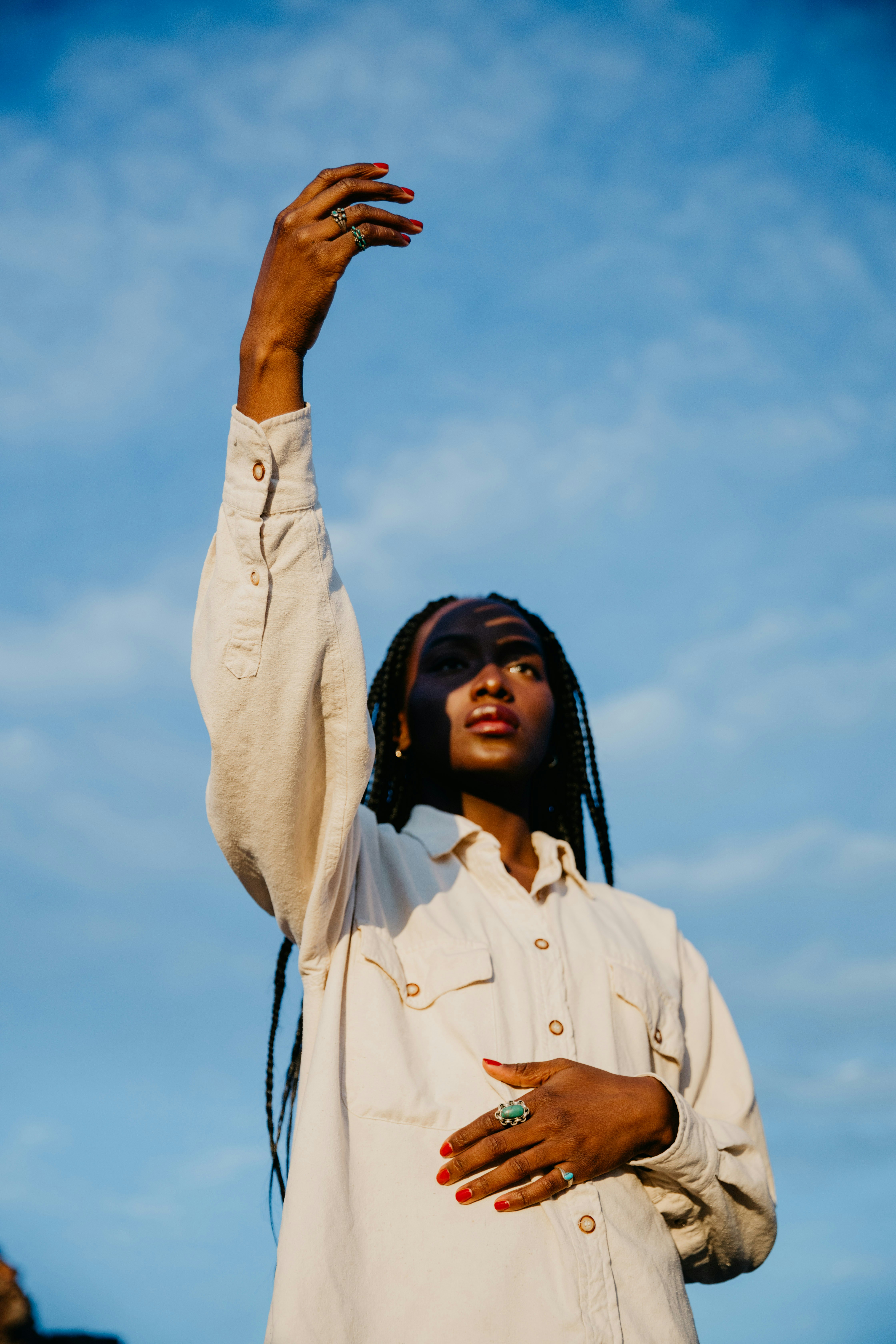 Raised Arm Against a Cerulean Sky: A Portrait of Quiet Confidence