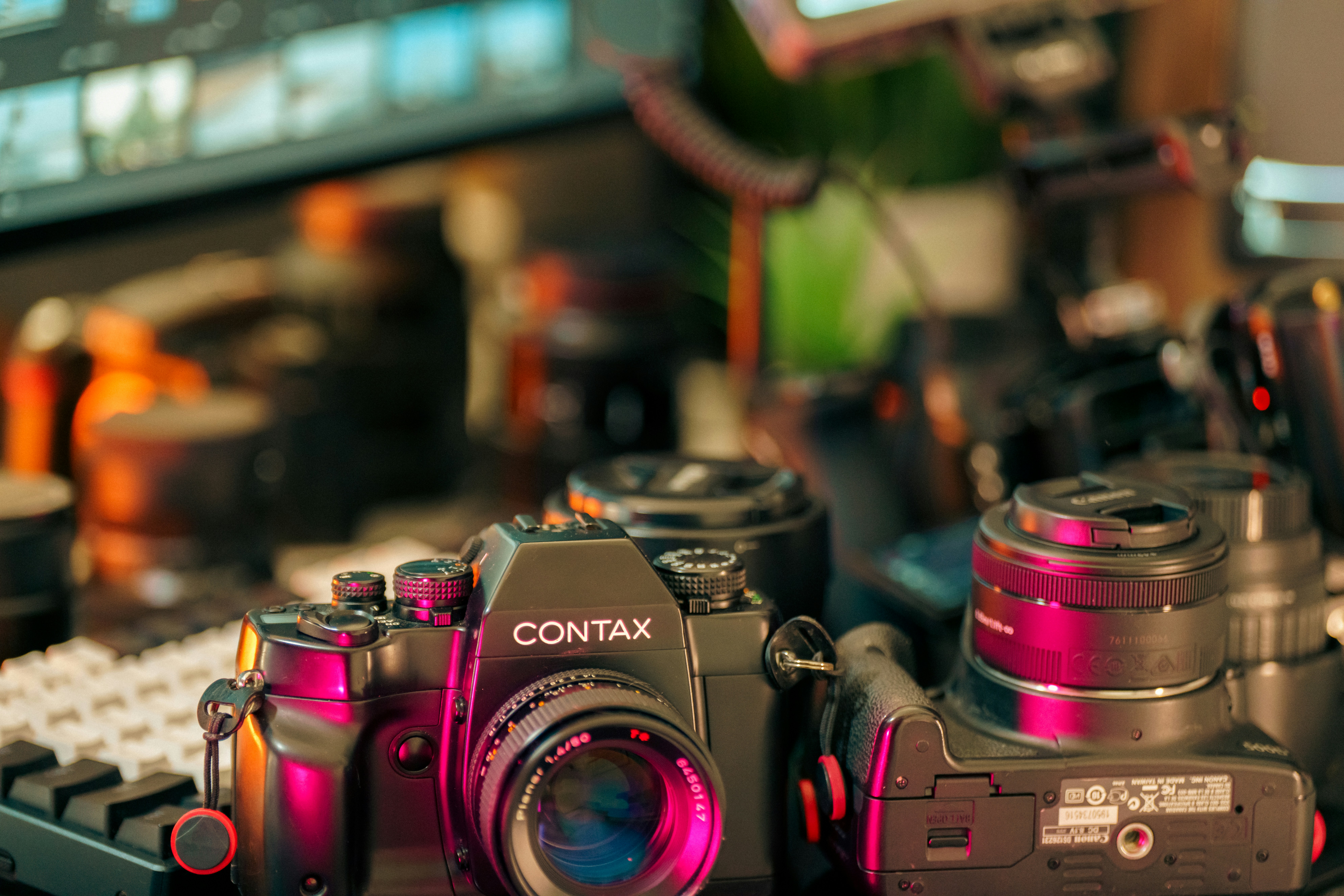 Neon-Hued Contax Centerstage on a Cluttered Studio Desk