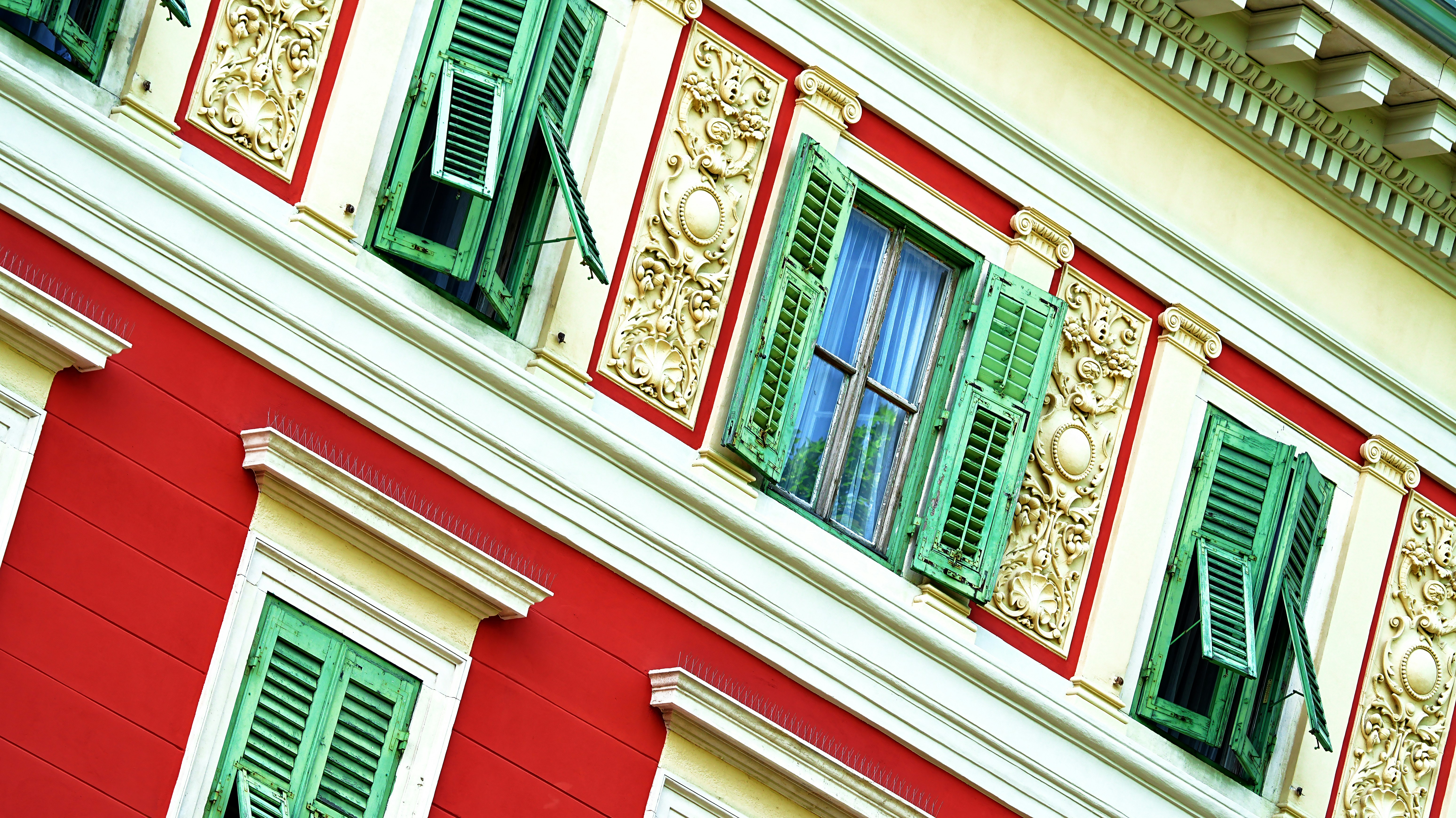 Emerald Shutters, Crimson Facade: Ornamented Architecture in Red and Gold