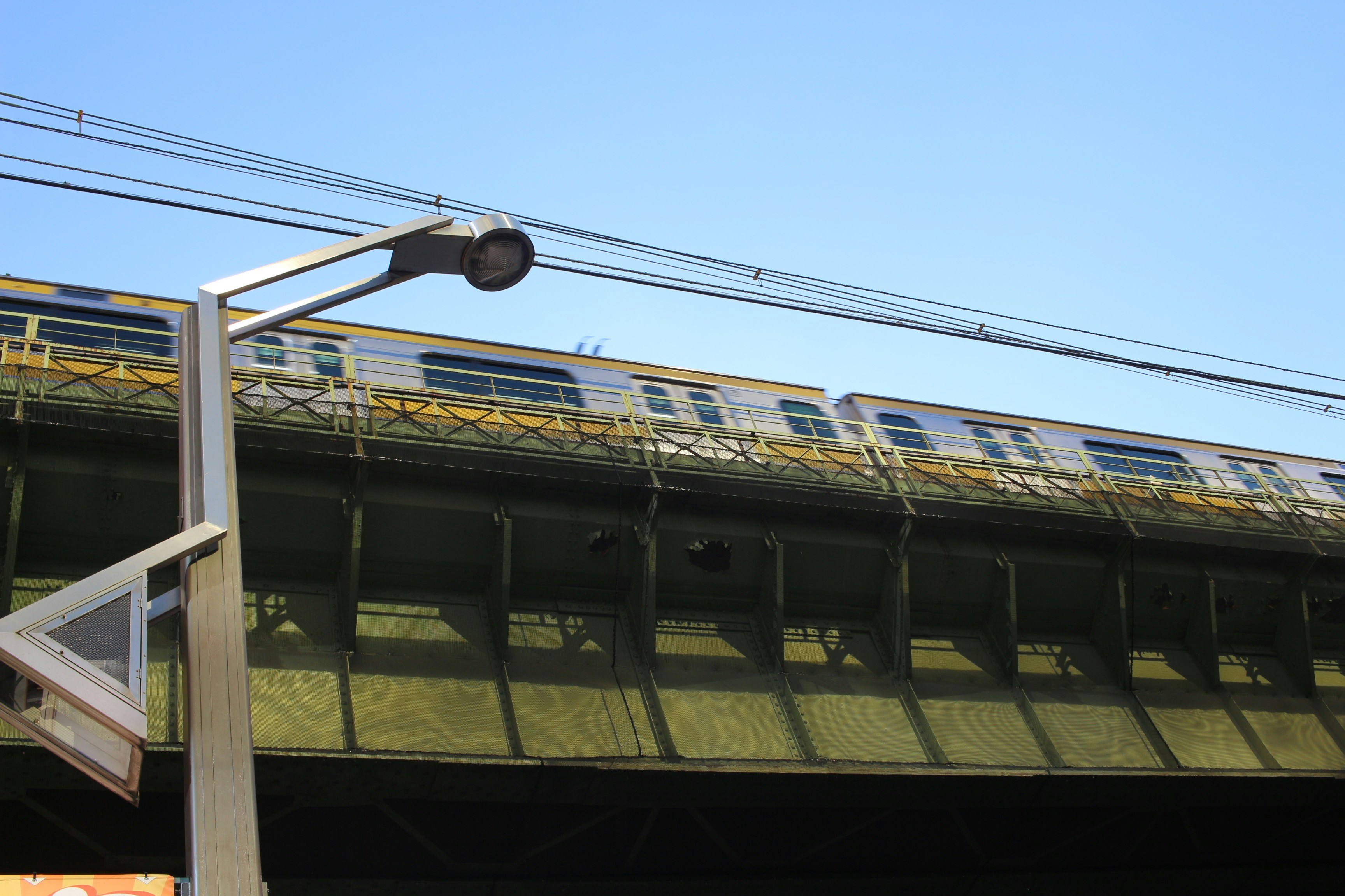 Skyward Rails: a commuter train glides over a sunlit iron bridge