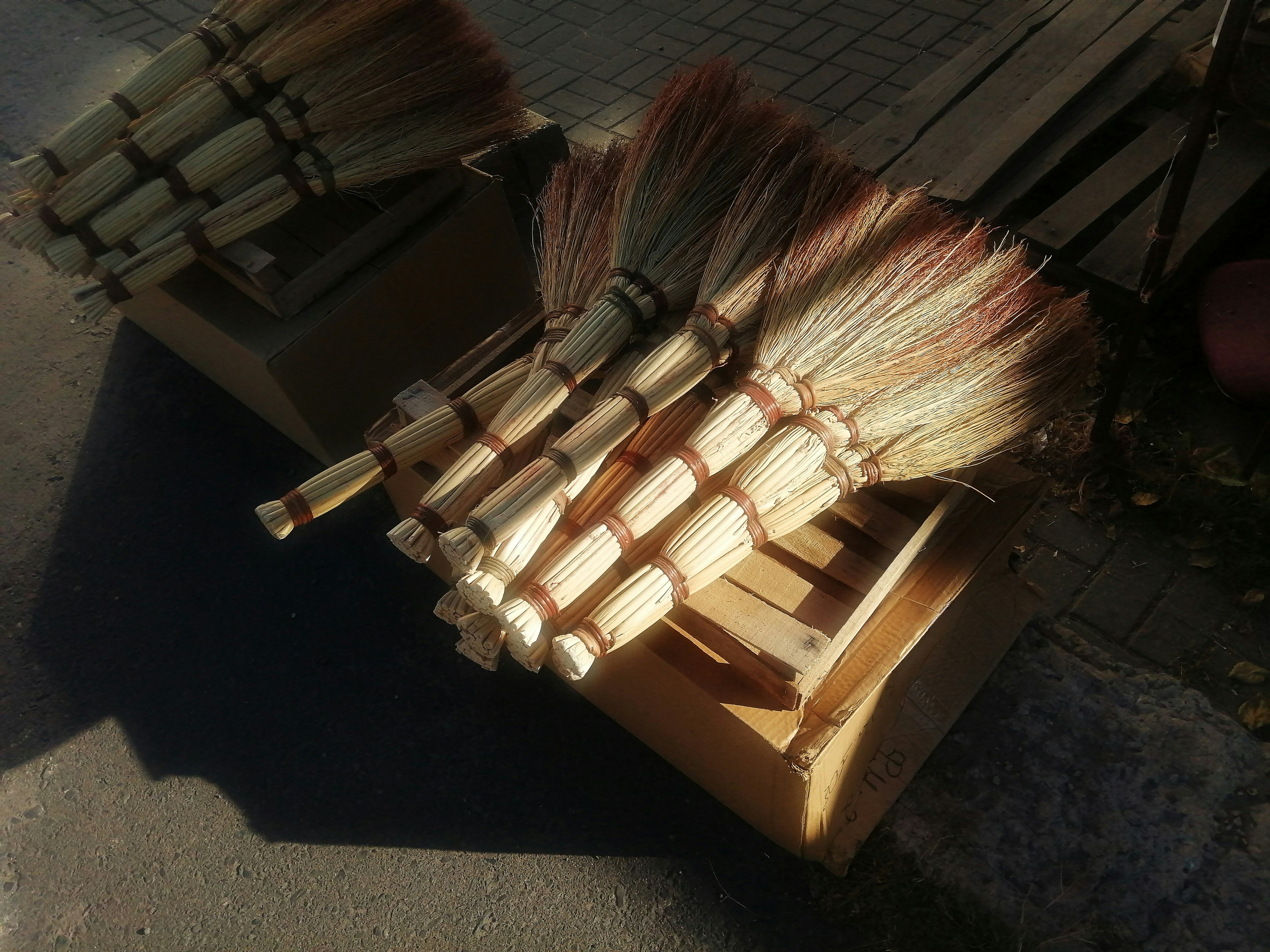 Several small brooms tied together on a wooden surface