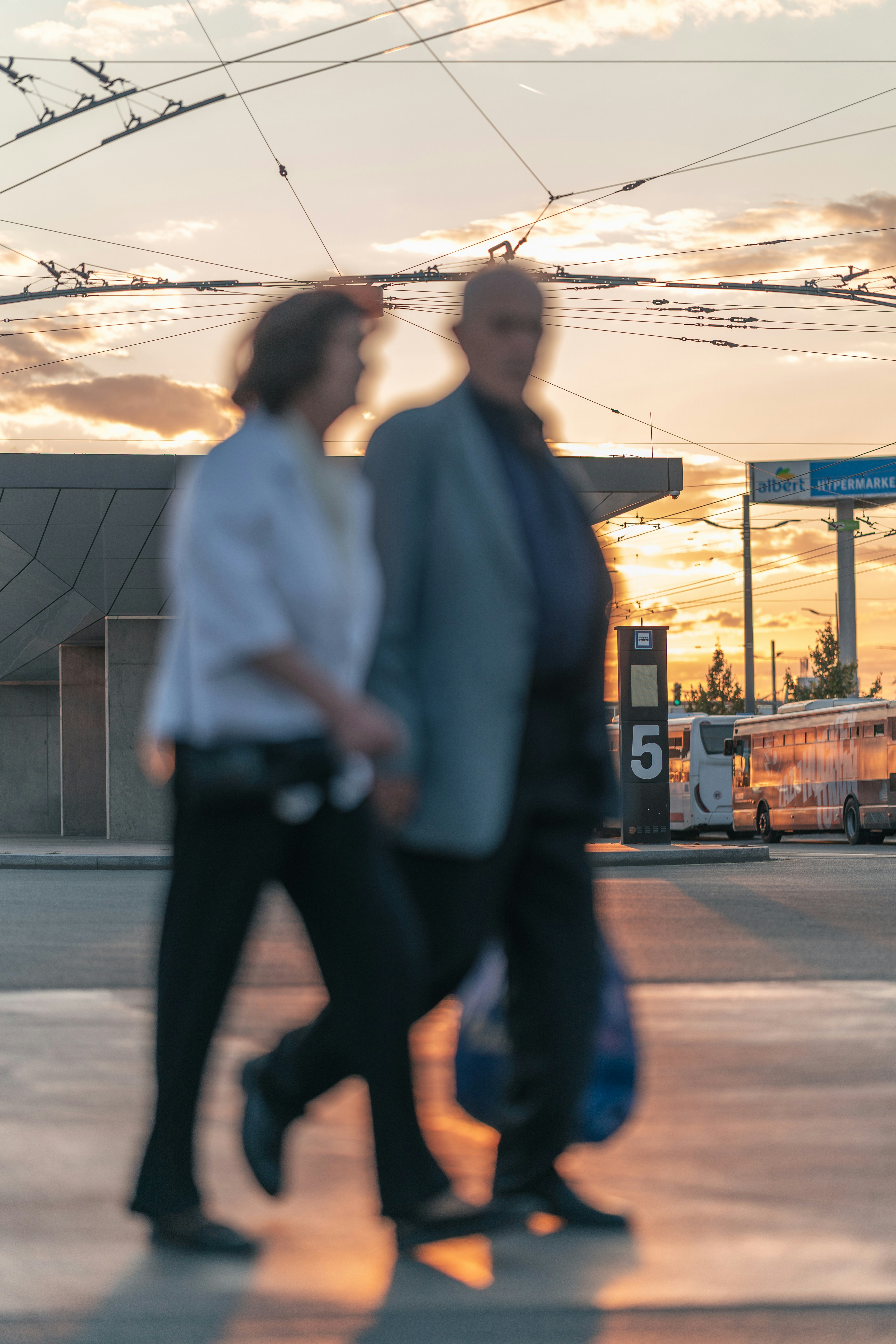 old happy coule walking on bus station in sunset
