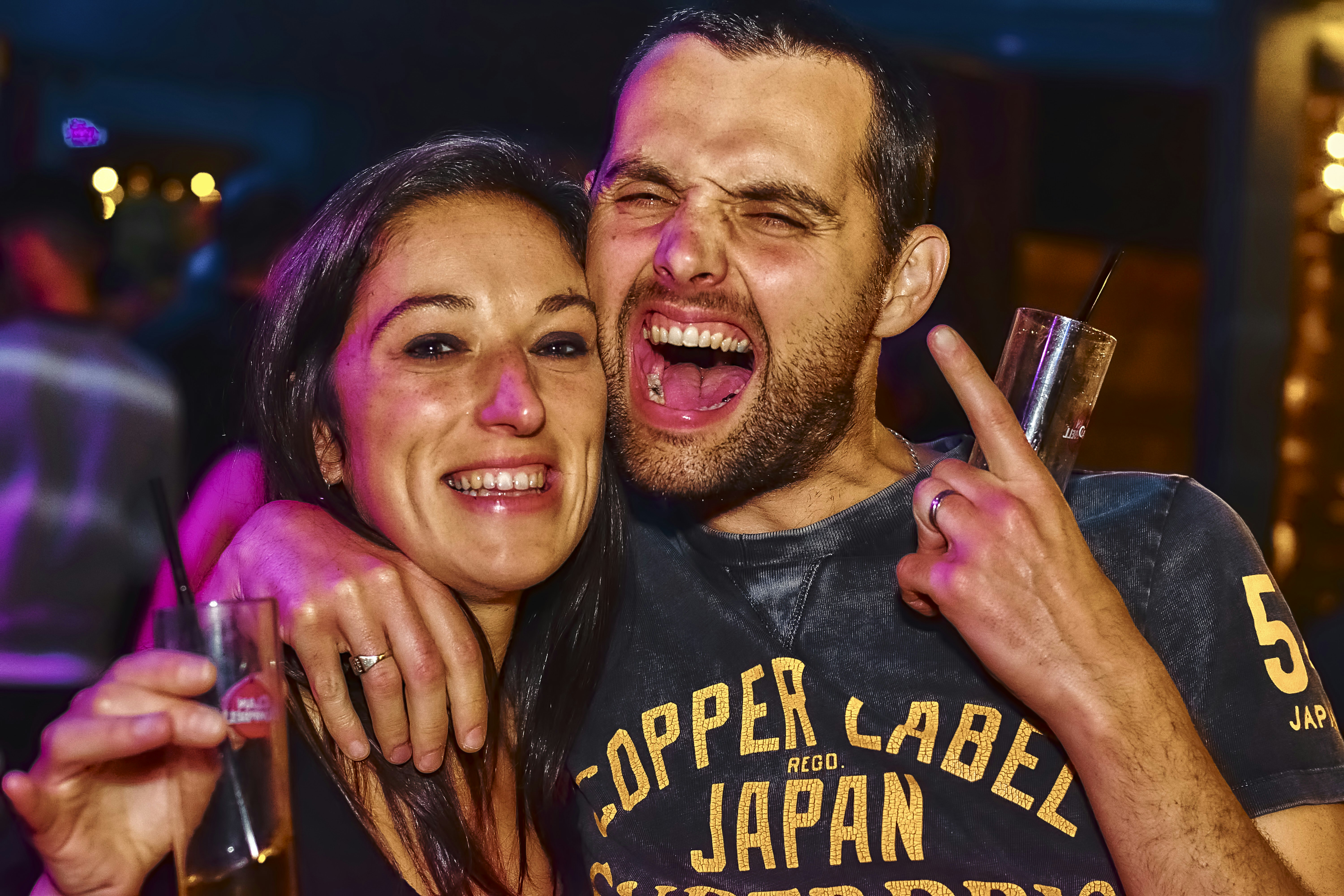 Neon Nights and Cheers: A candid hug at a buzzing club