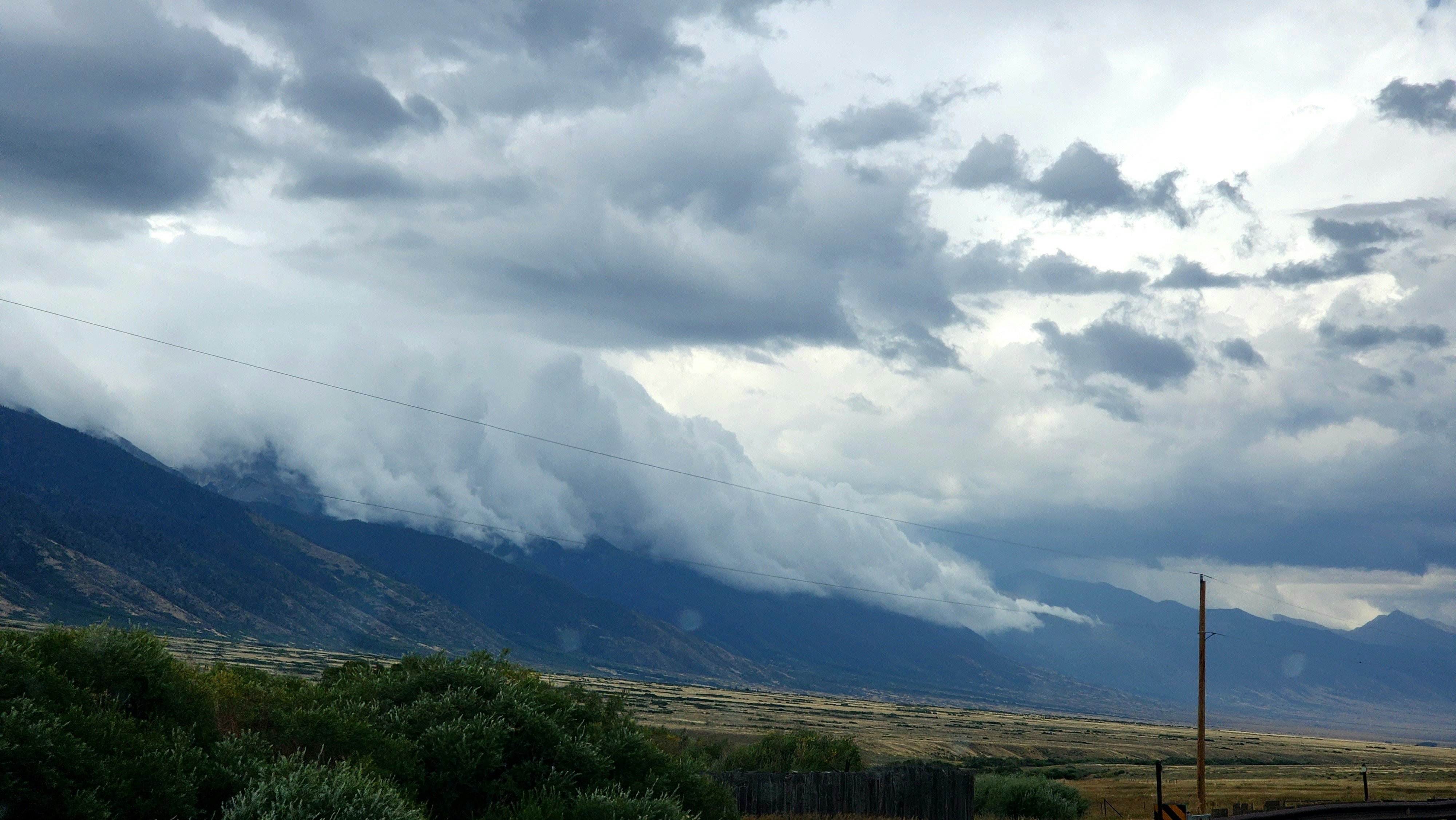 Storm-Wrapped Peaks Over a Quiet Valley