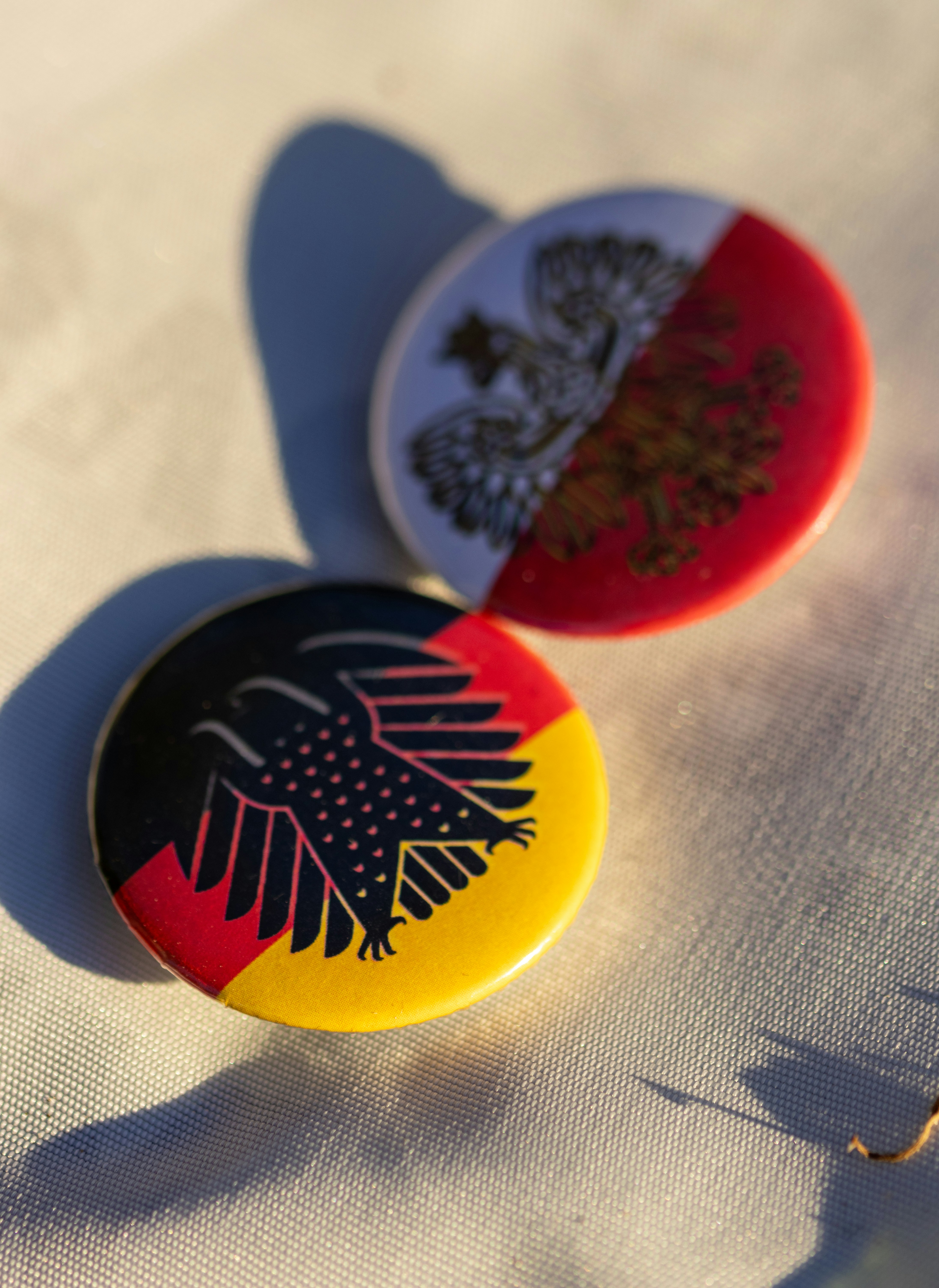 Sunlit Enamel Eagles: Twin German Badges on White Linen