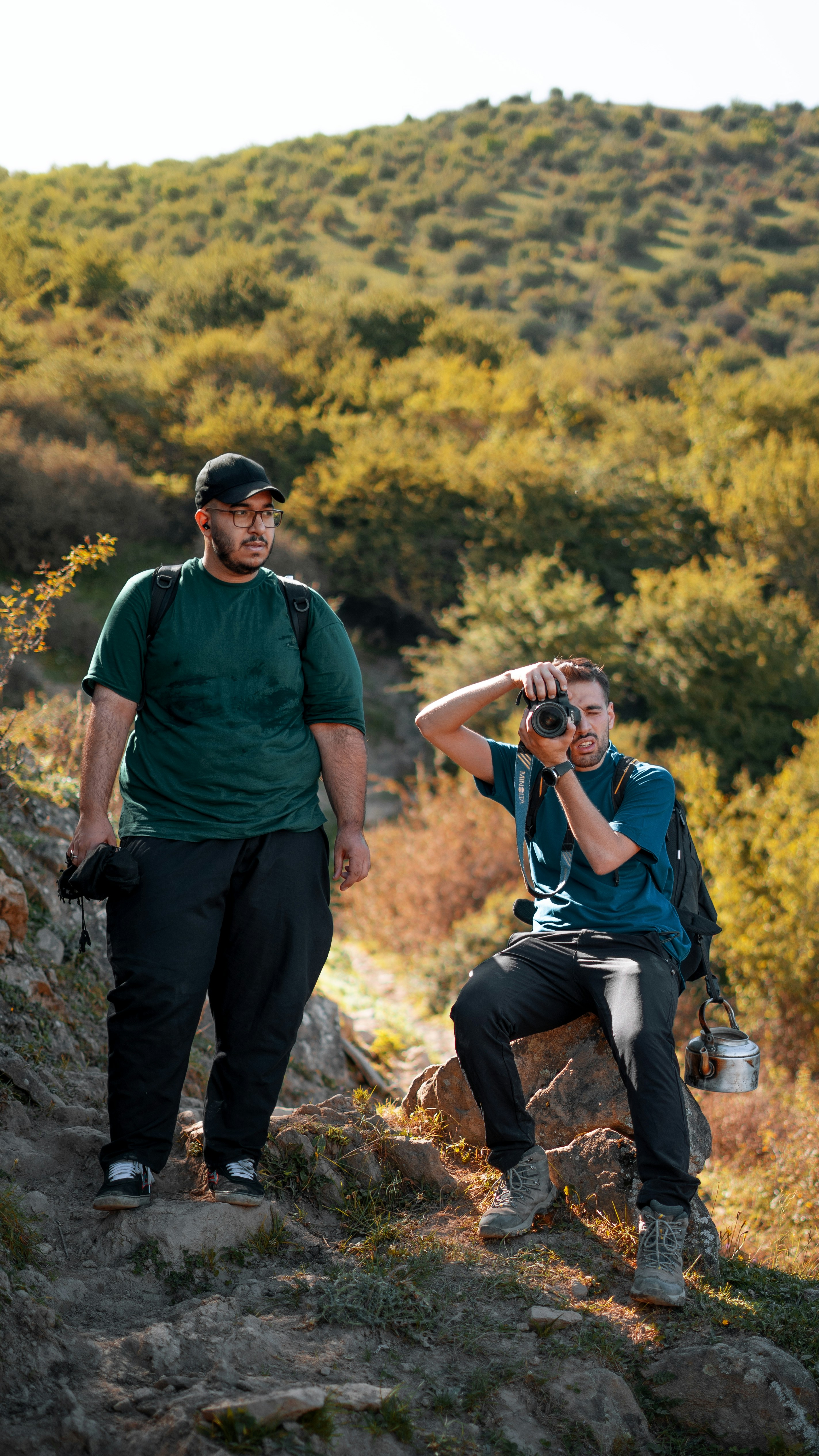 Golden Slopes, Shared Focus: Two Hikers on a Sunlit Ridge
