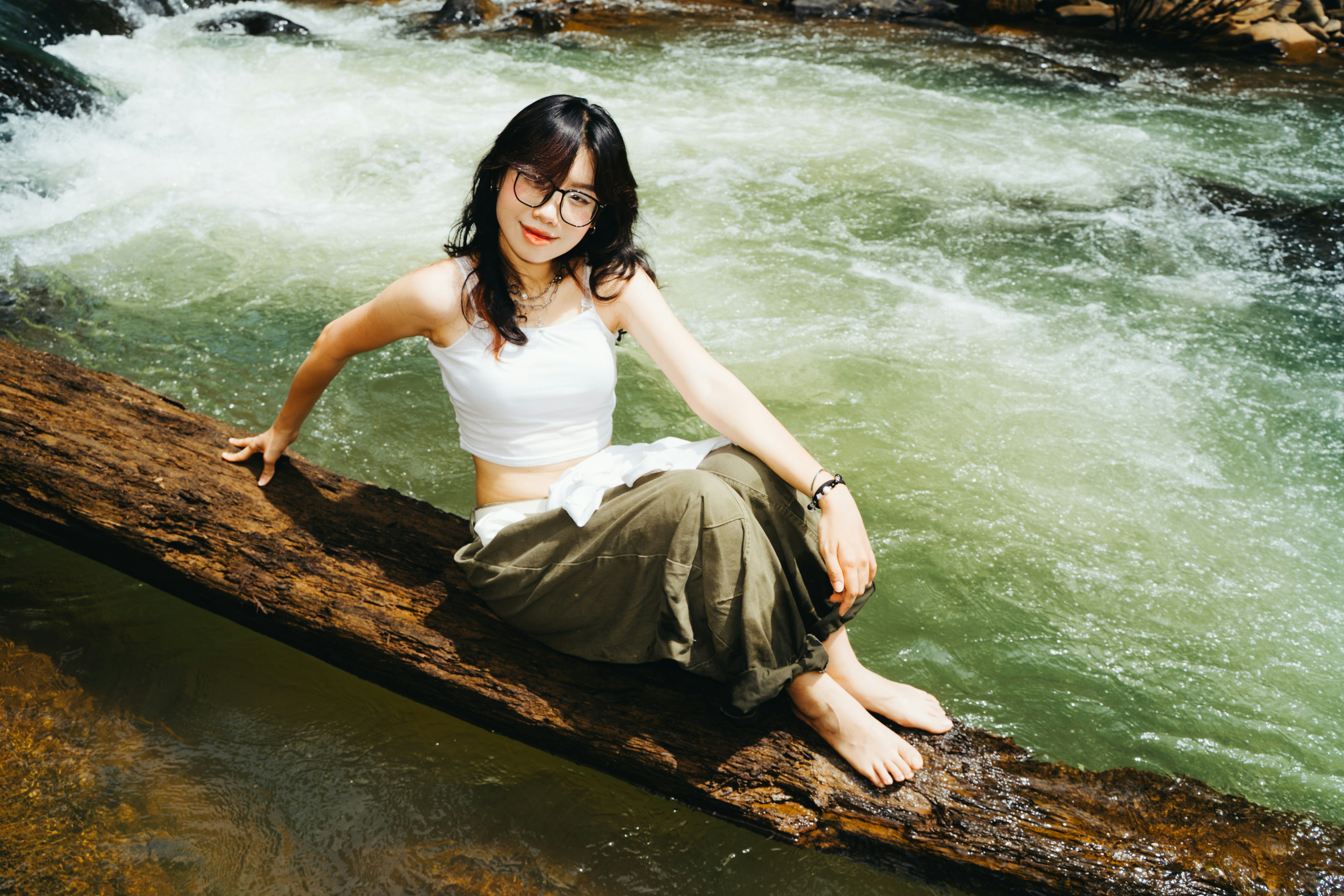 Sitting on a Weathered Log, Woman by Turbulent Green River