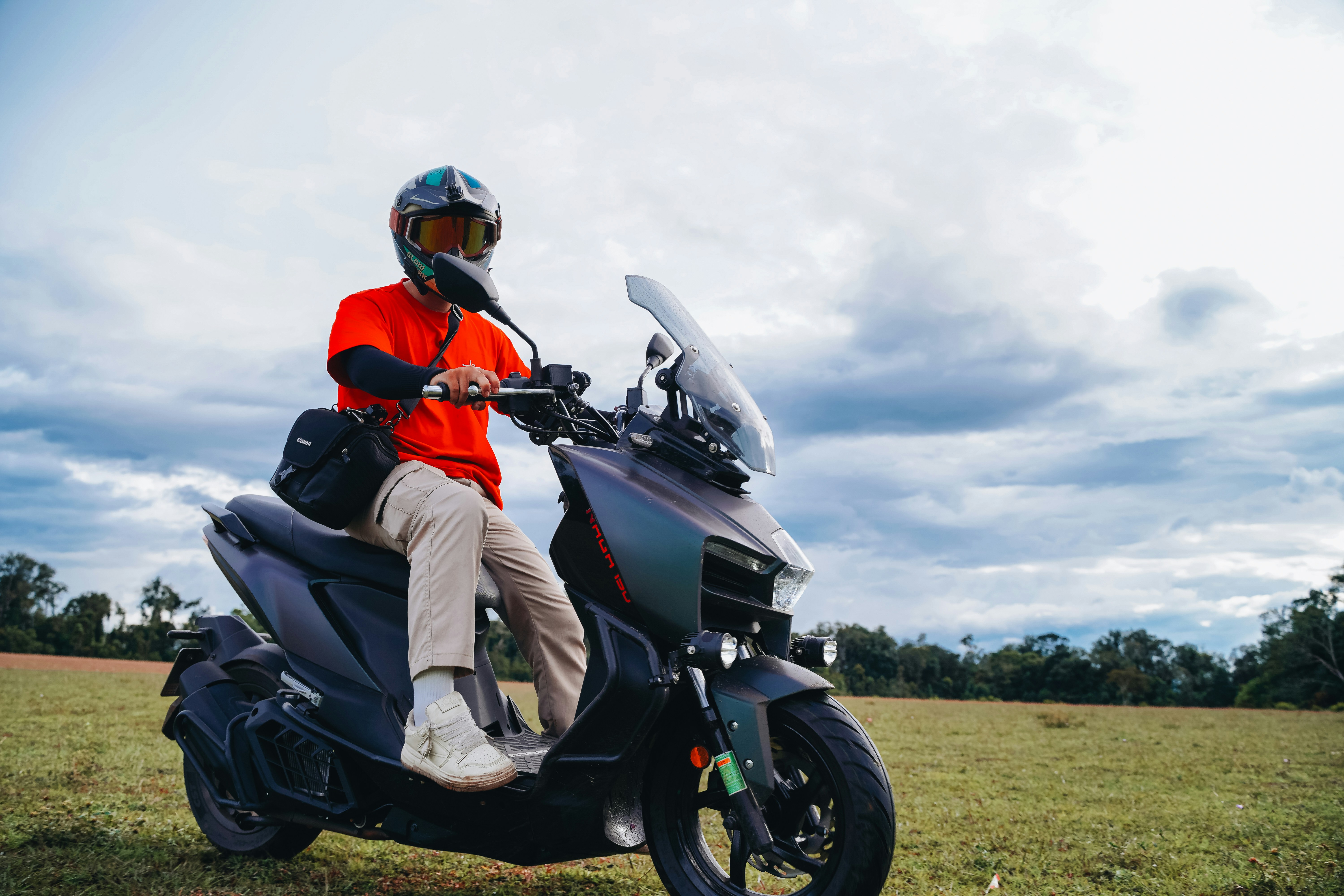 Red Shirt, Black Scooter, Open Field: A Quiet Portrait of Motion