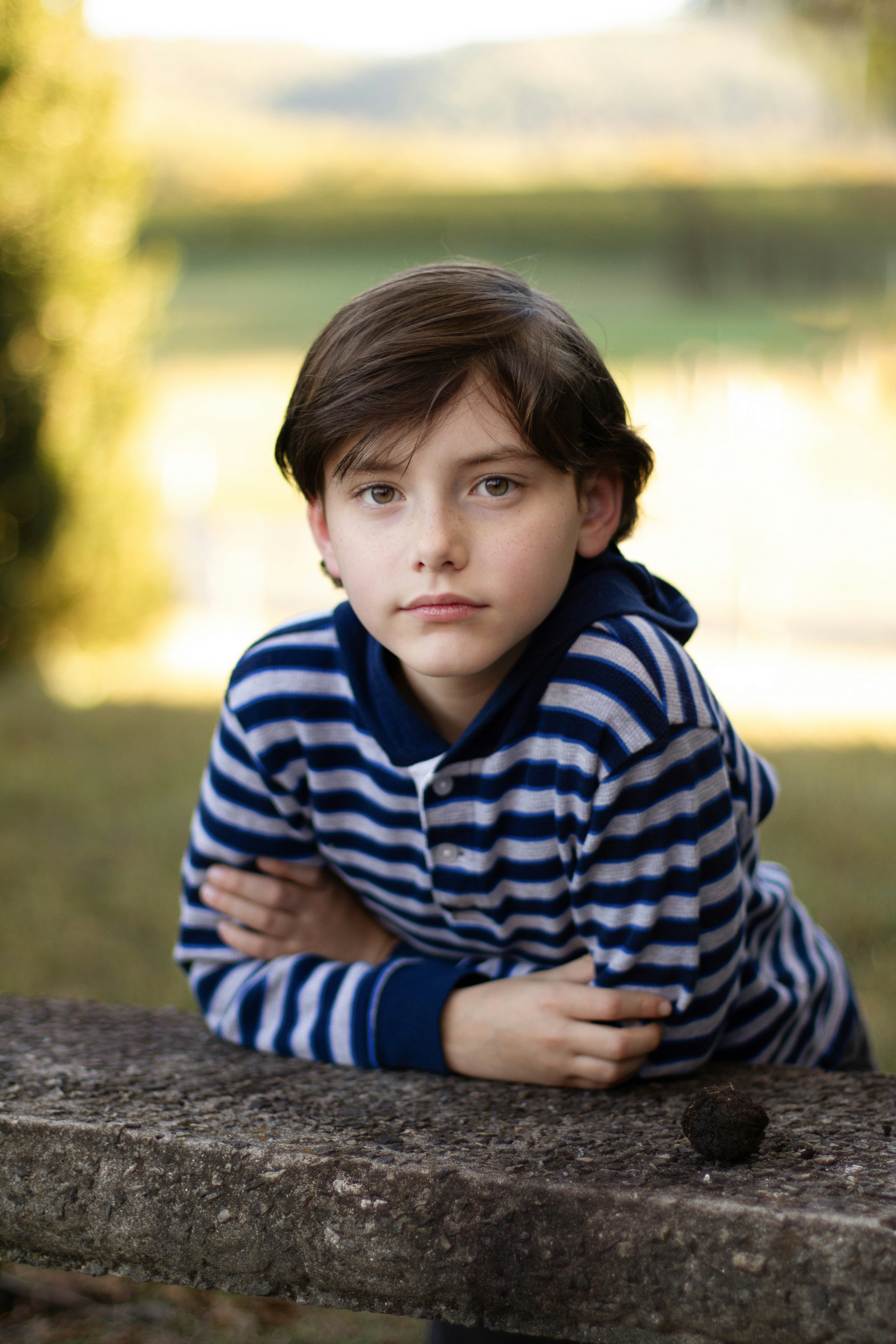Stripes and Soft Light: Portrait of a Boy by a Sunlit Park Bench