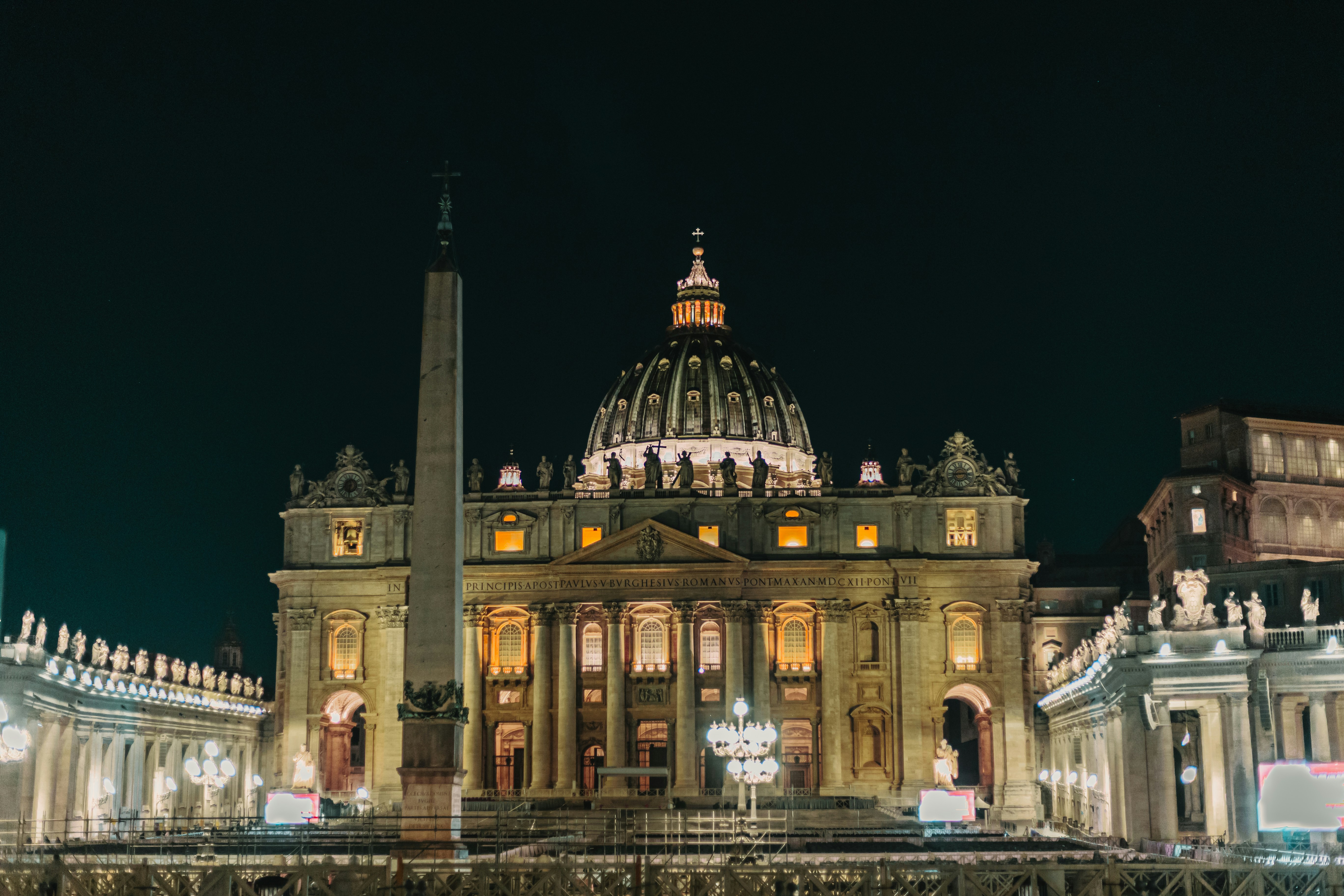 St. Peter's Basilica and obelisk in St. Peter's Square, illuminated at night.